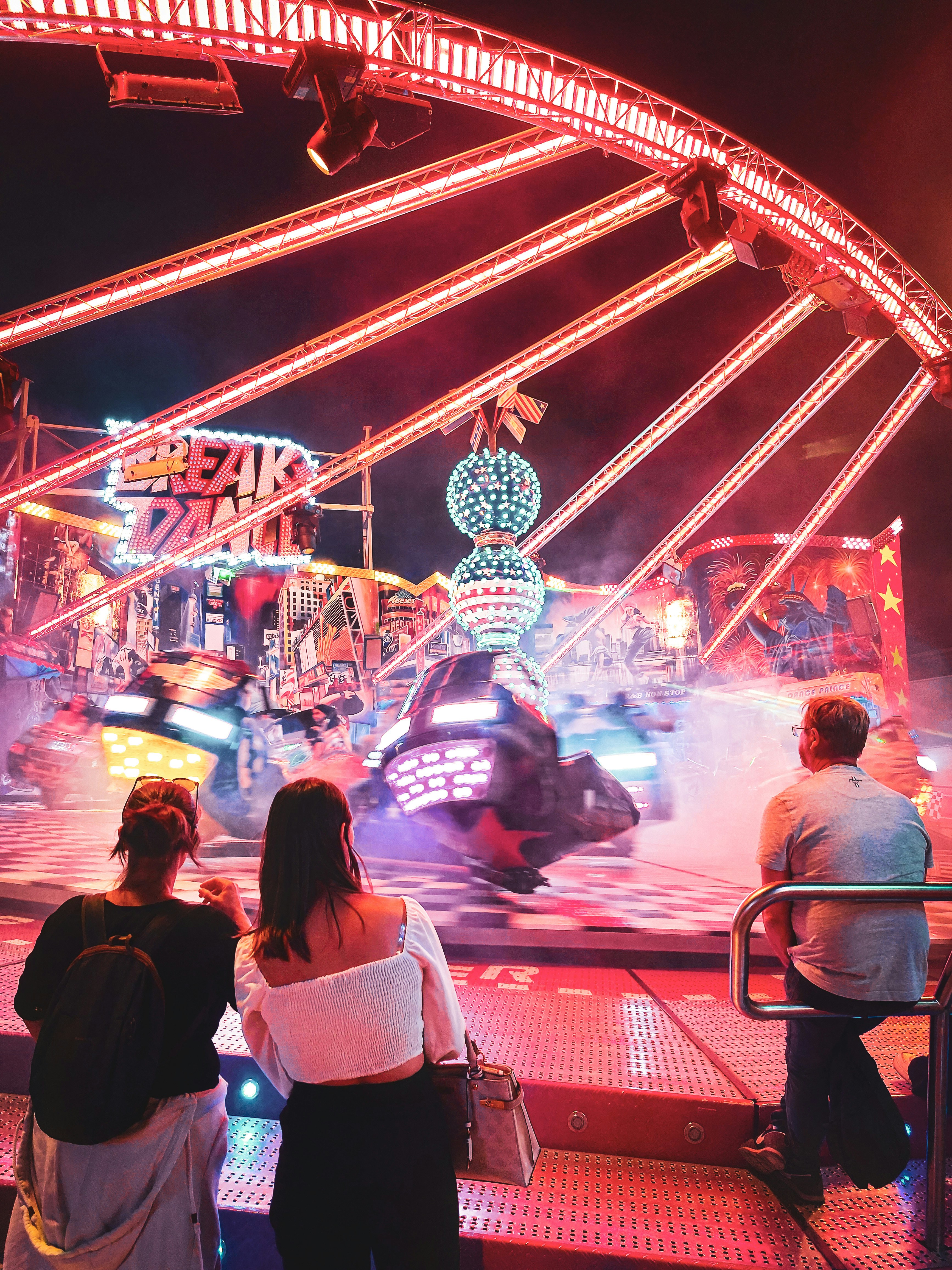A group of people standing around a carnival ride photo – Free France ...