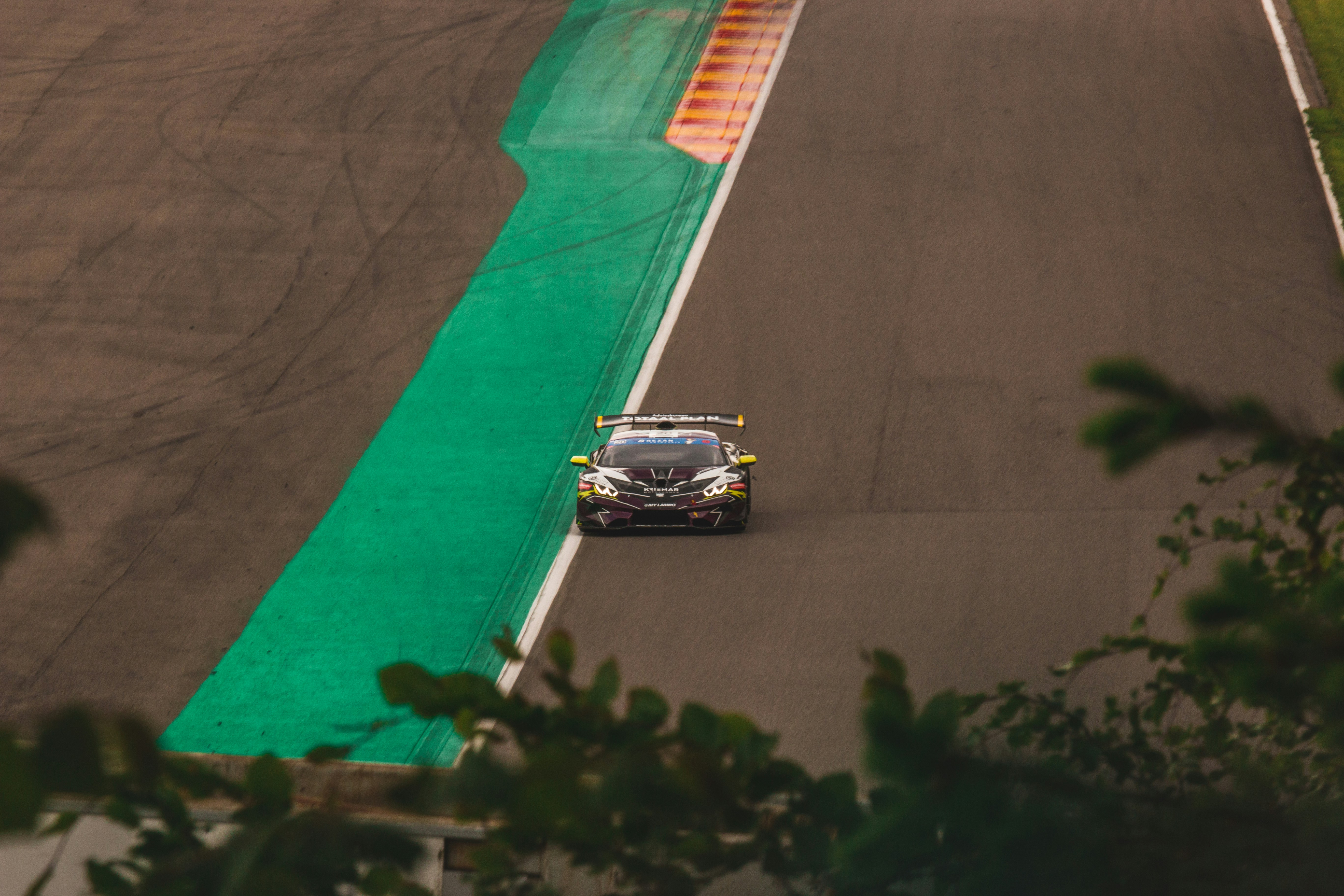 A race car driving down a race track photo – Free Lamborghini svj Image ...