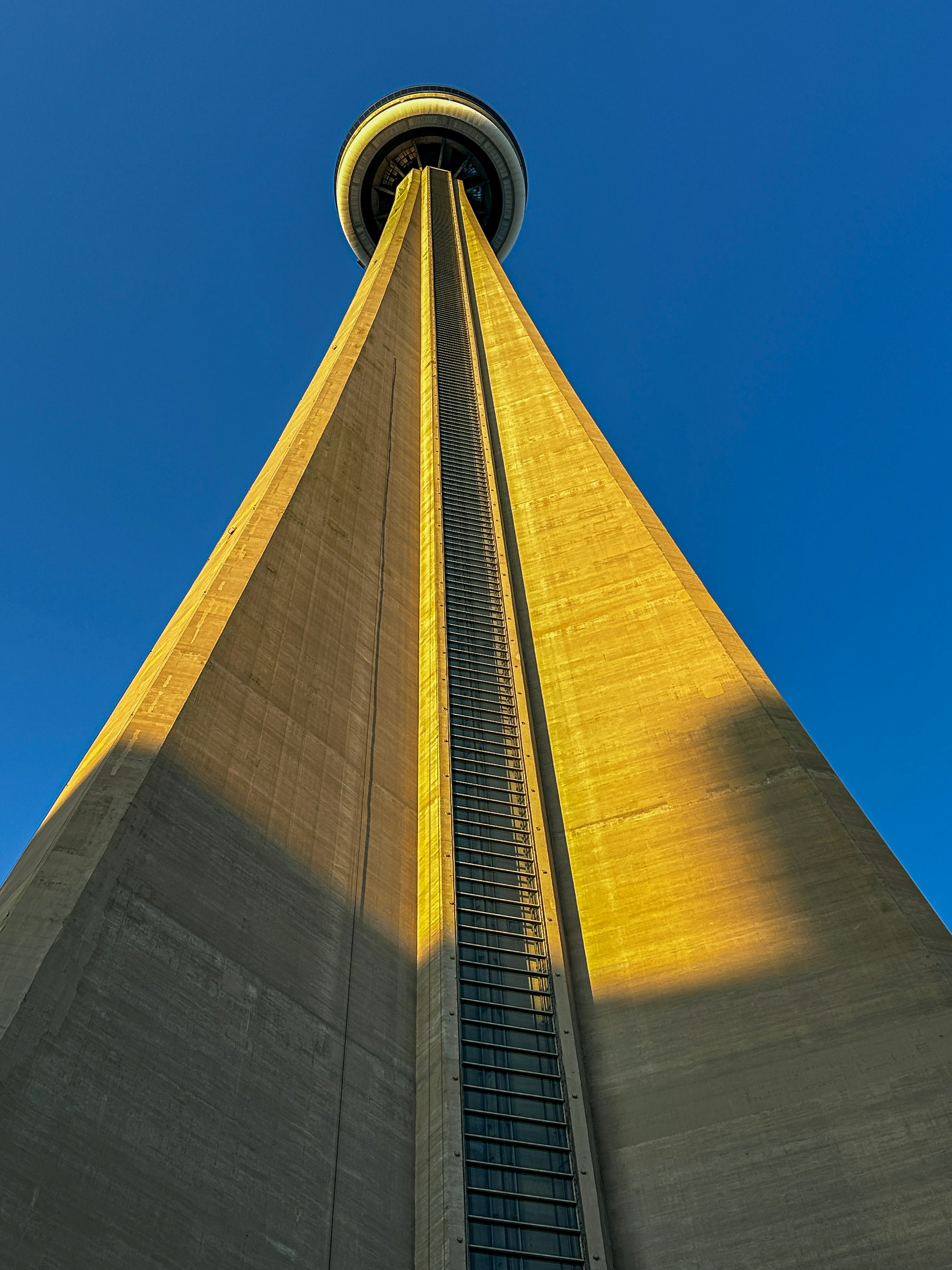 Golden Spine Ascends: A Tower Reaches for a Clear Blue Sky