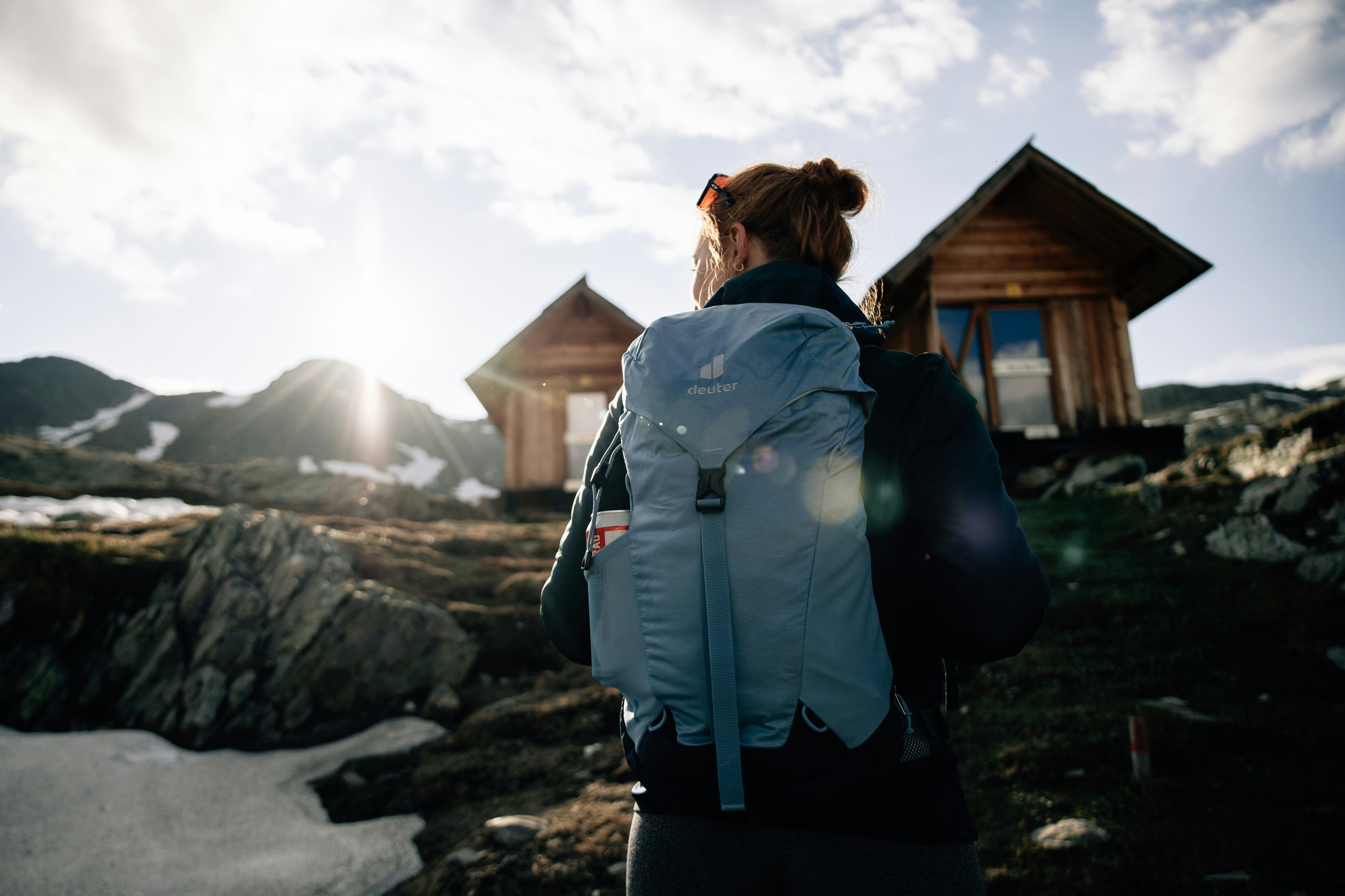 A woman with a backpack standing in front of a cabin photo – Free Tirol ...