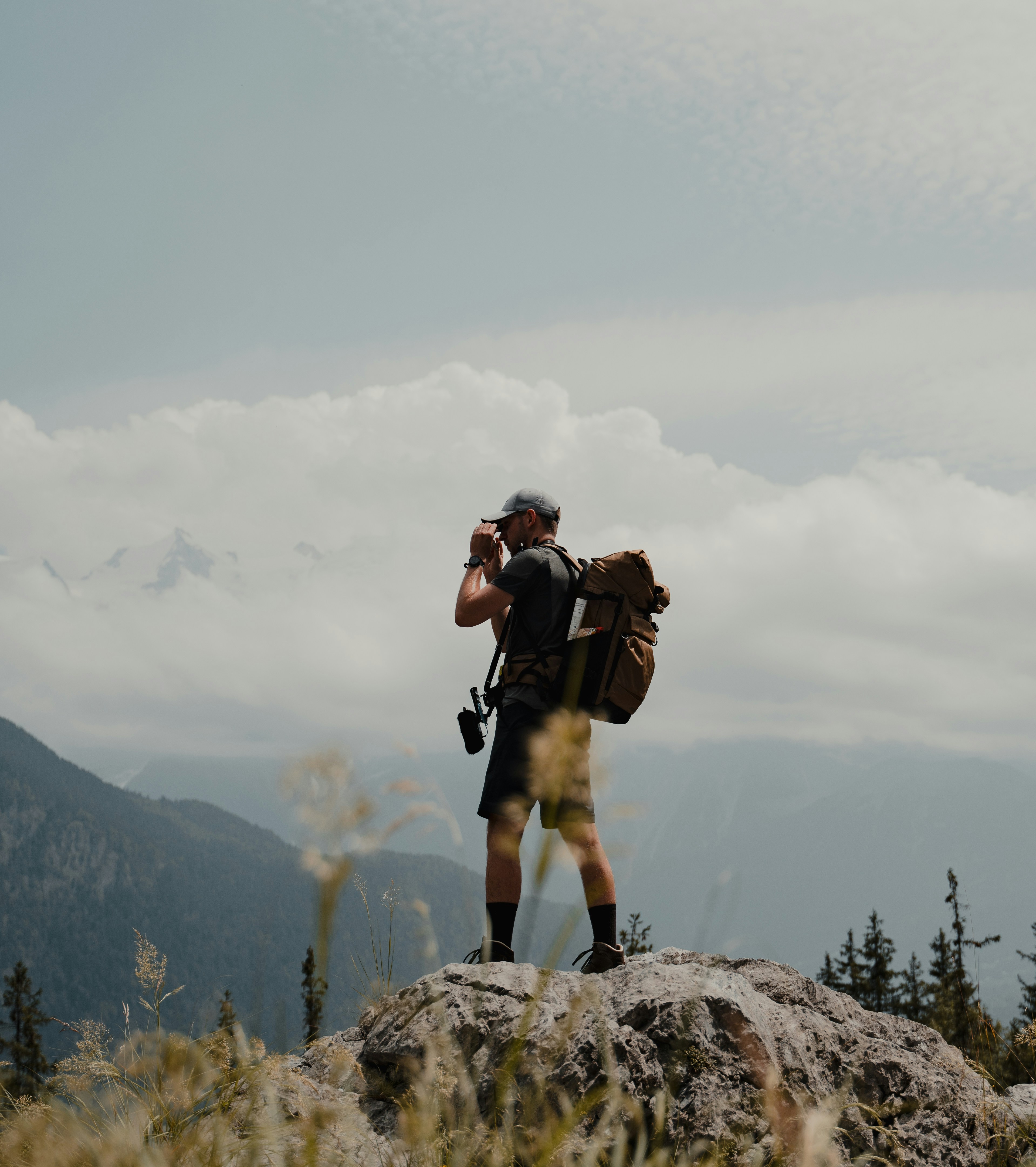 A man standing on top of a rock with a camera photo – Free France Image ...