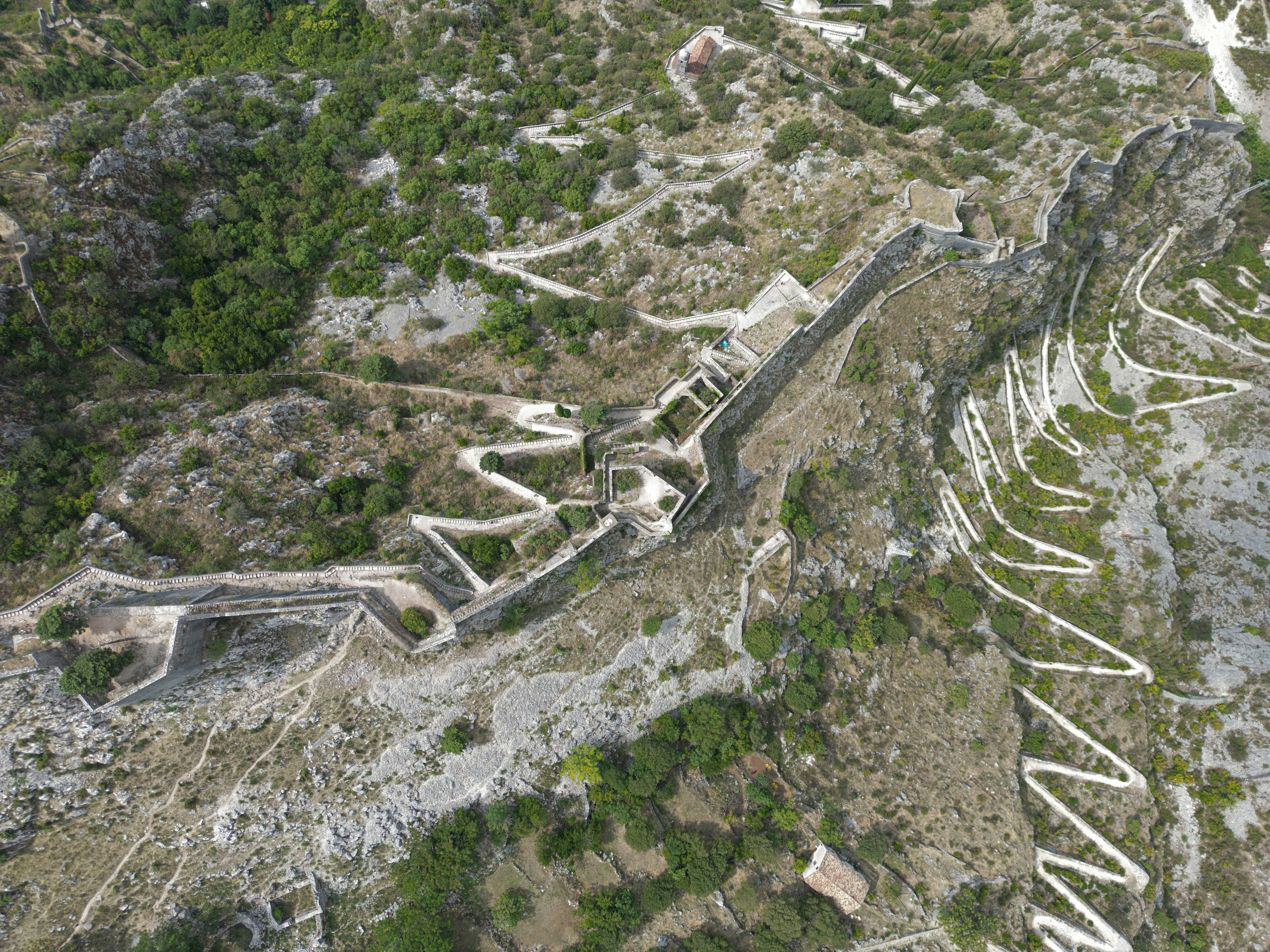 Ridgebound Fortress: Zigzag Stone Walls Woven Across a Sunlit Slope