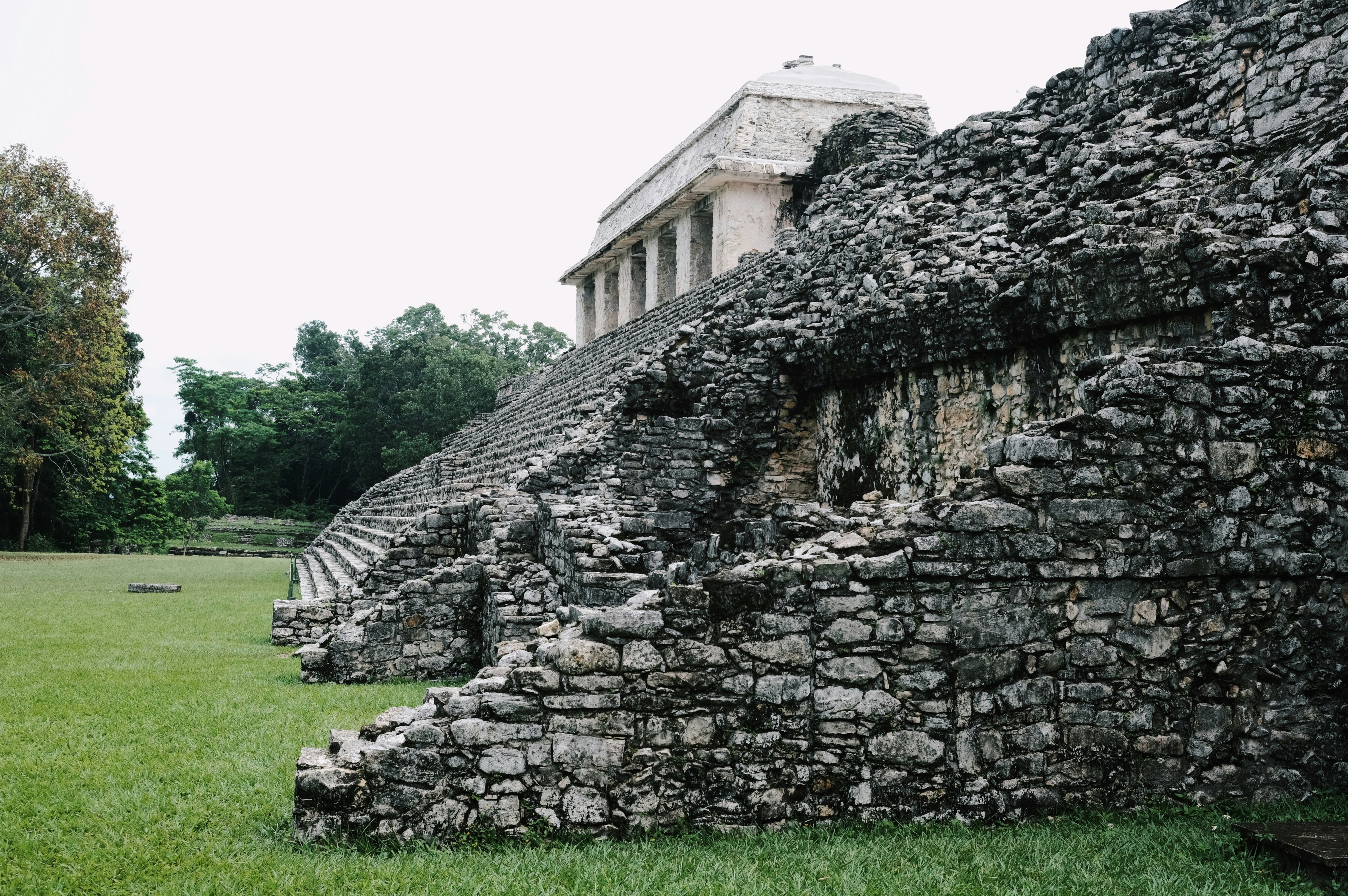 A large stone structure sitting on top of a lush green field photo ...