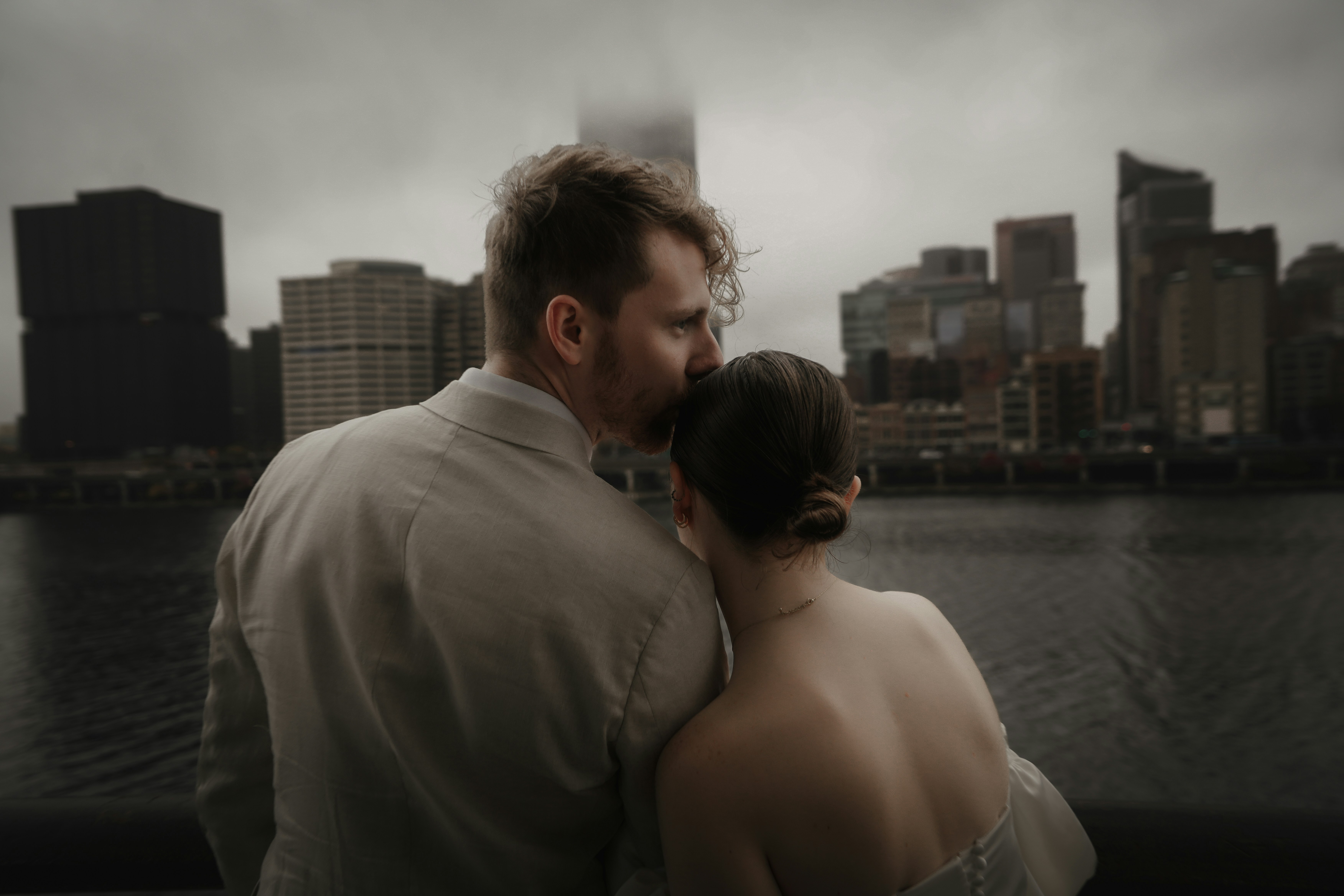 Harbor Embrace: A Kiss Beneath the Distant City