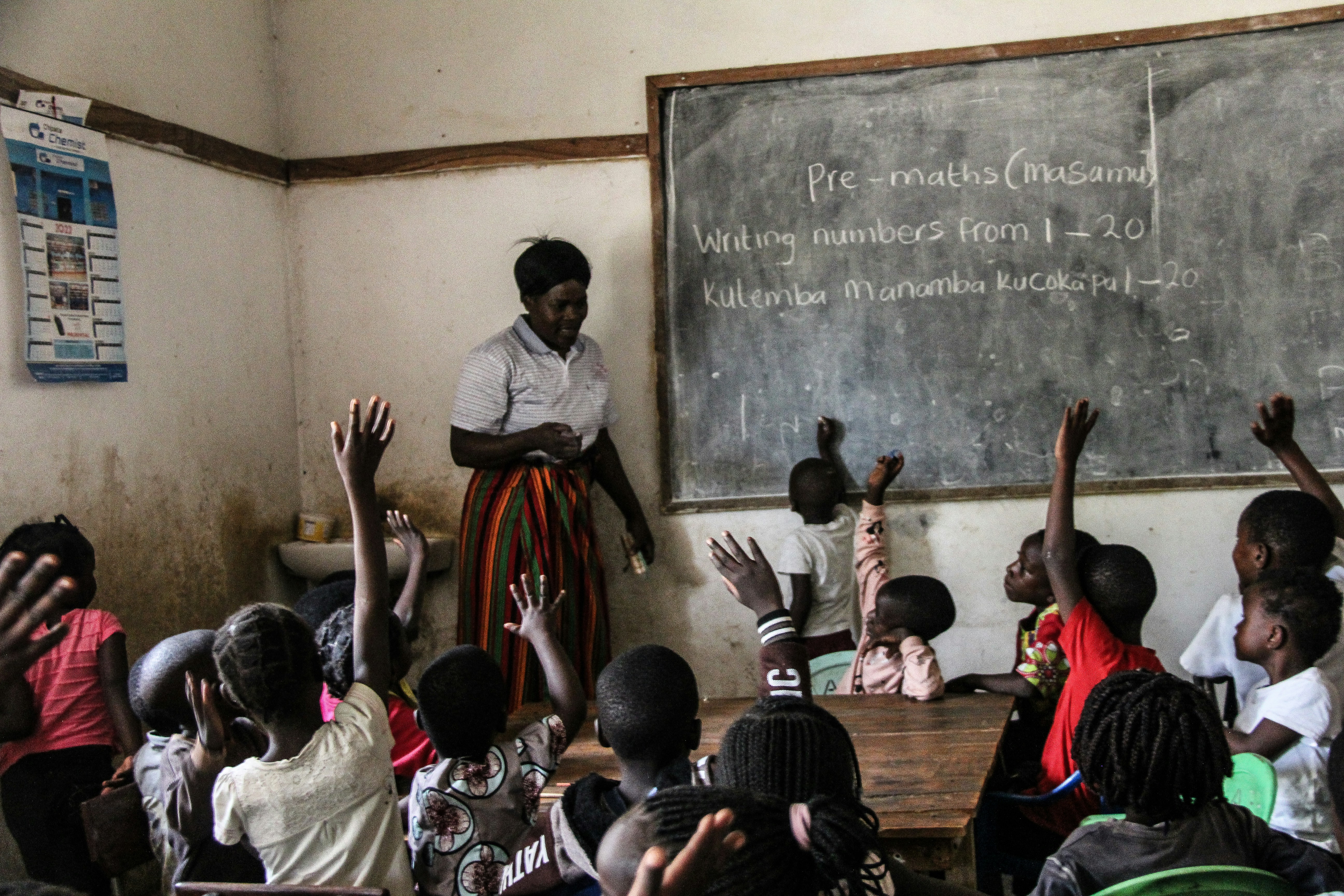 A woman teaching a class of children in a classroom photo – Free Person ...
