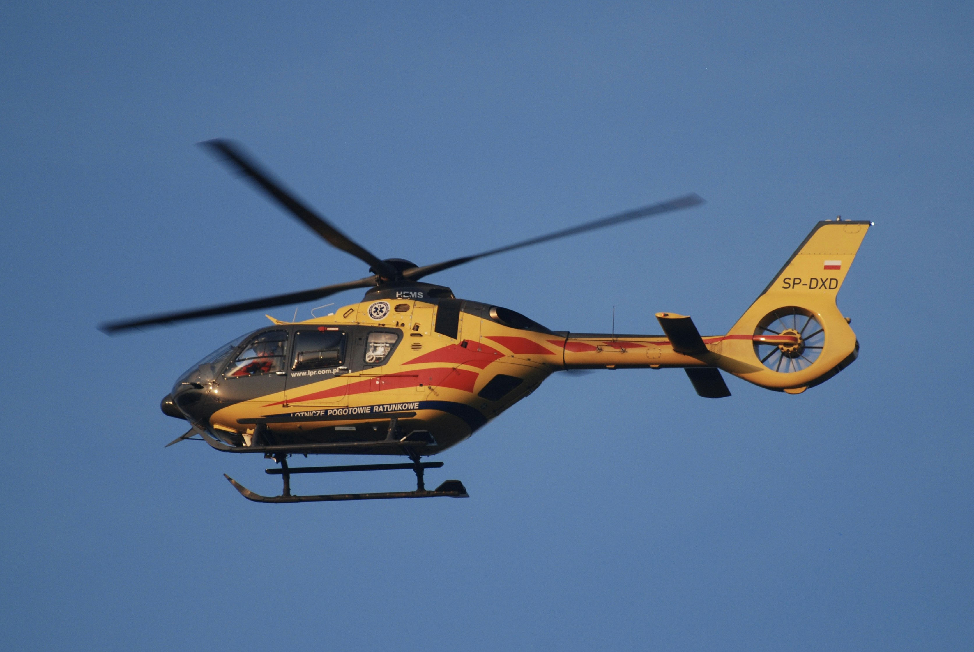 Yellow-and-red Rescue Helicopter Carving Through a Cobalt Sky