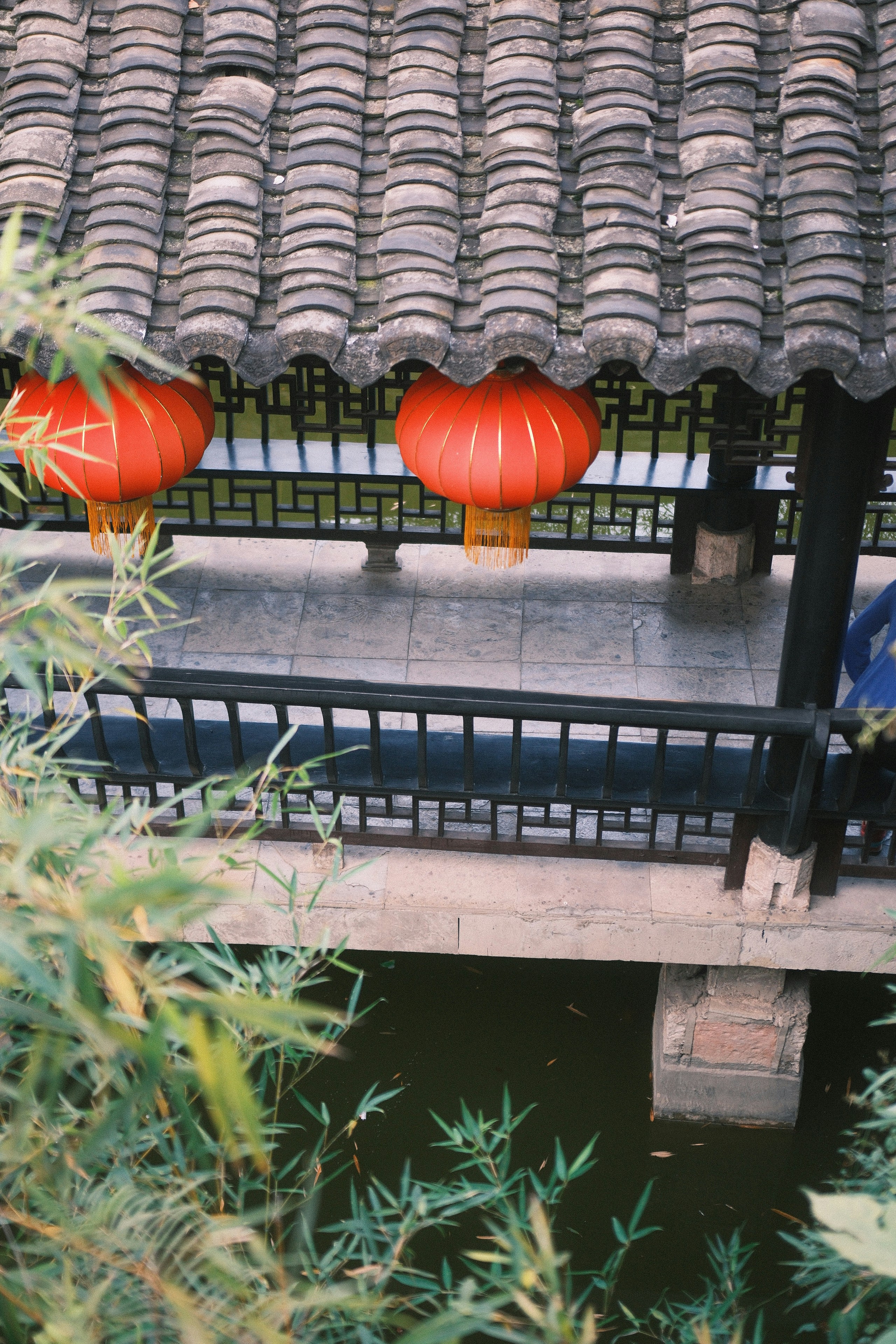 Red Lanterns Framed by a Tile Roof Over a Tranquil Canal