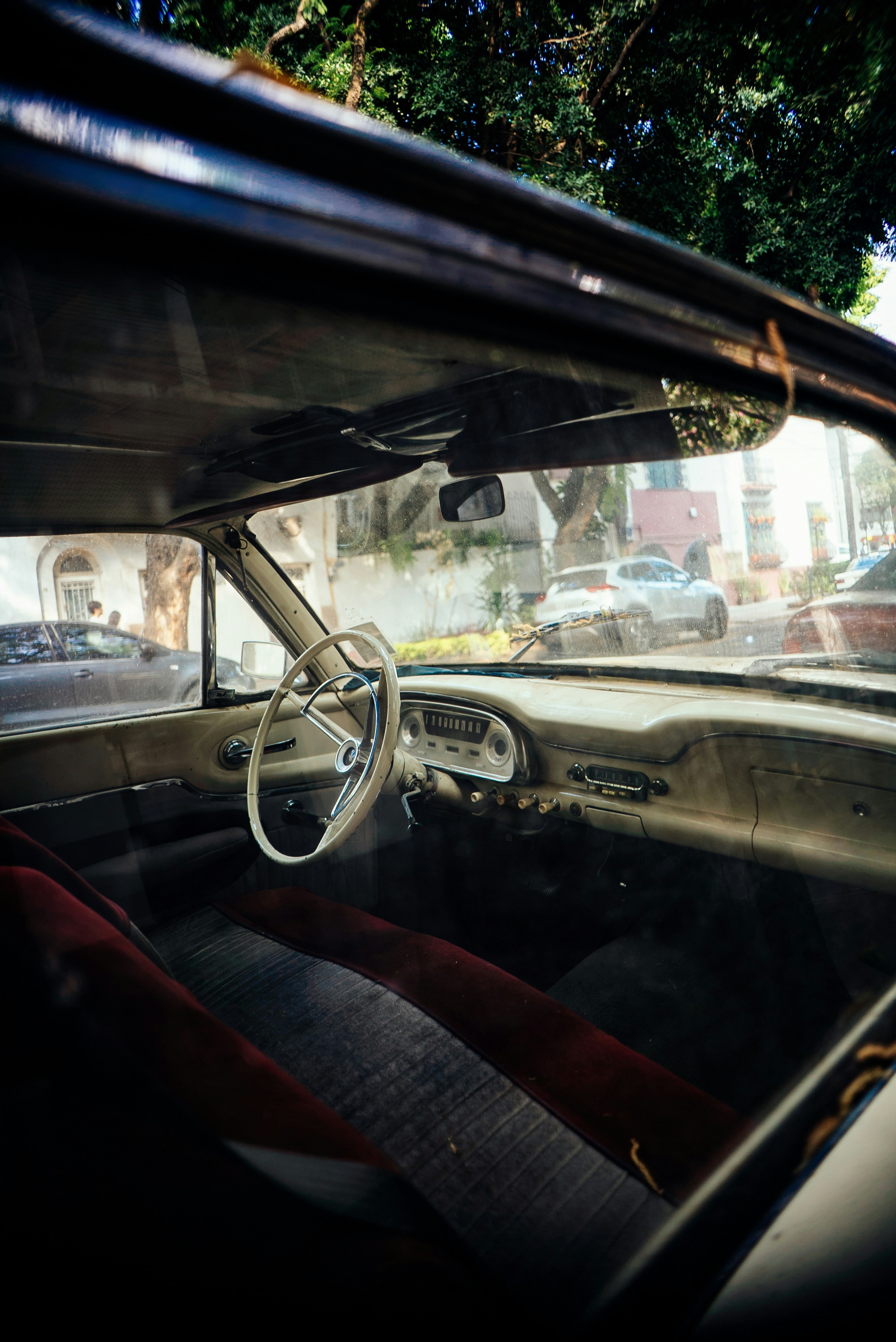 Sunlit Time Capsule: Velvet-Red Interior of a Vintage Sedan