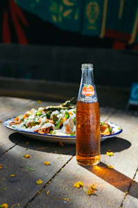 Amber Glass on a Sunlit Picnic Table with Topped Plate