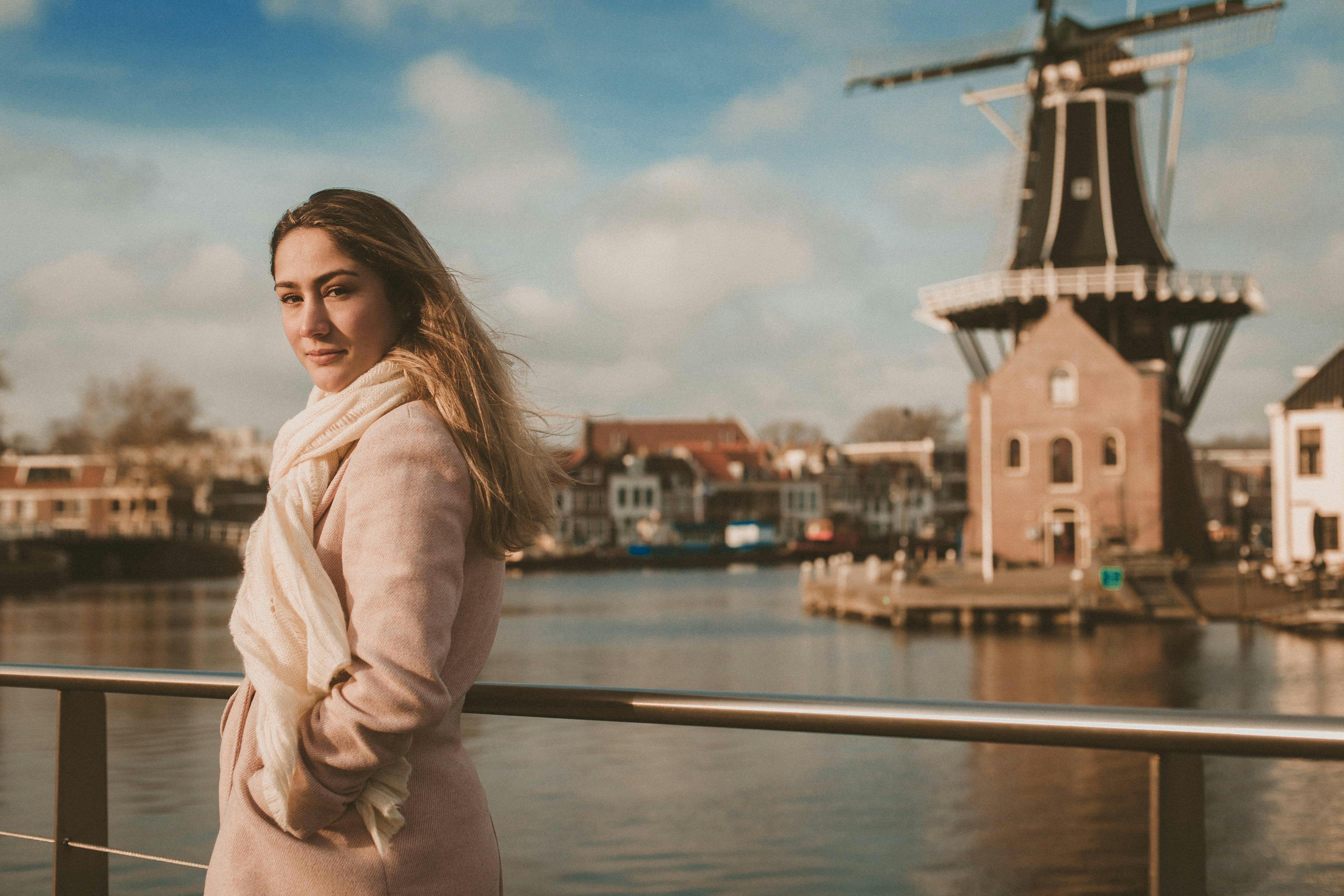 a woman standing on a bridge next to a body of water