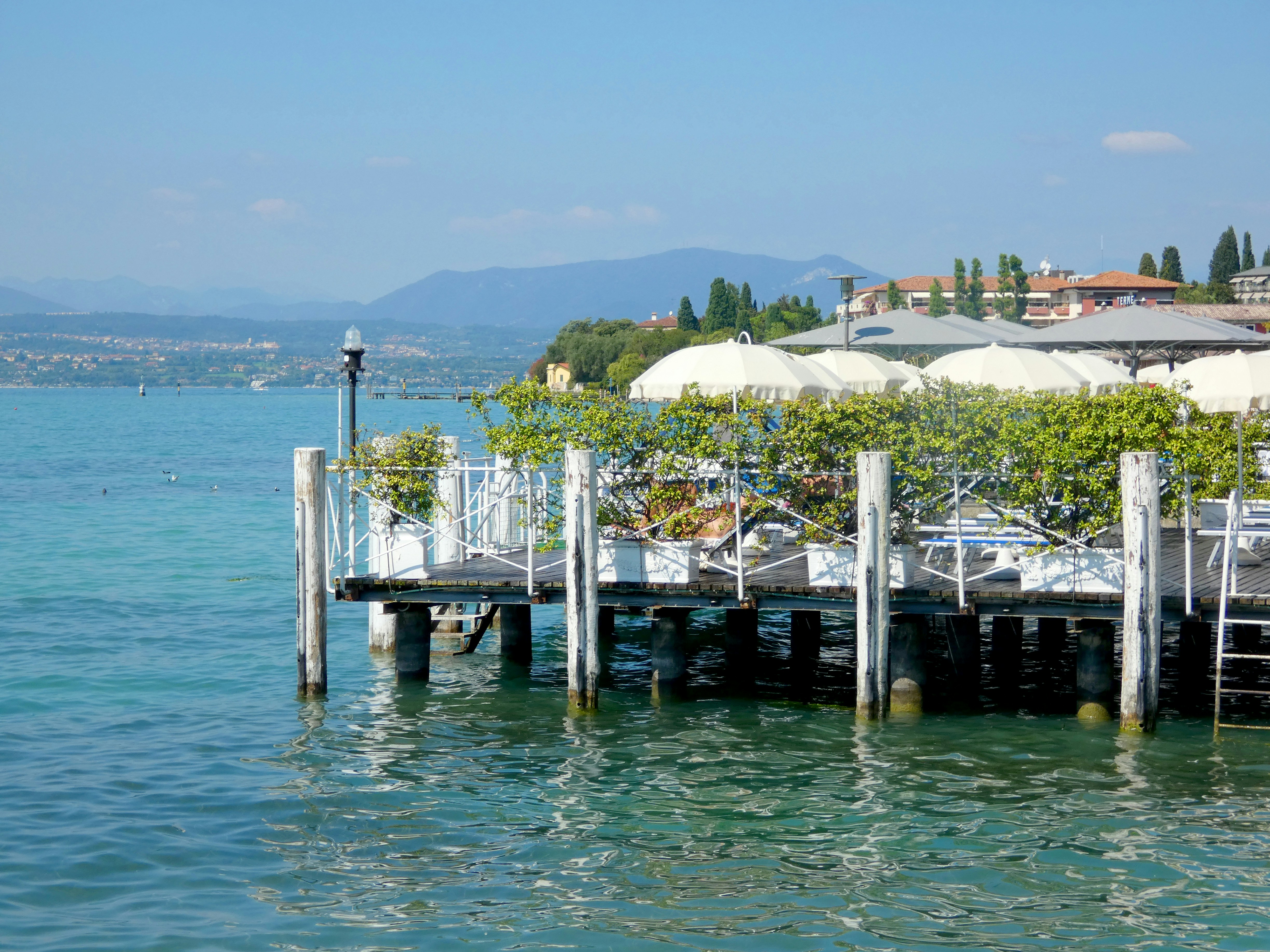 a boat dock with umbrellas and chairs on it