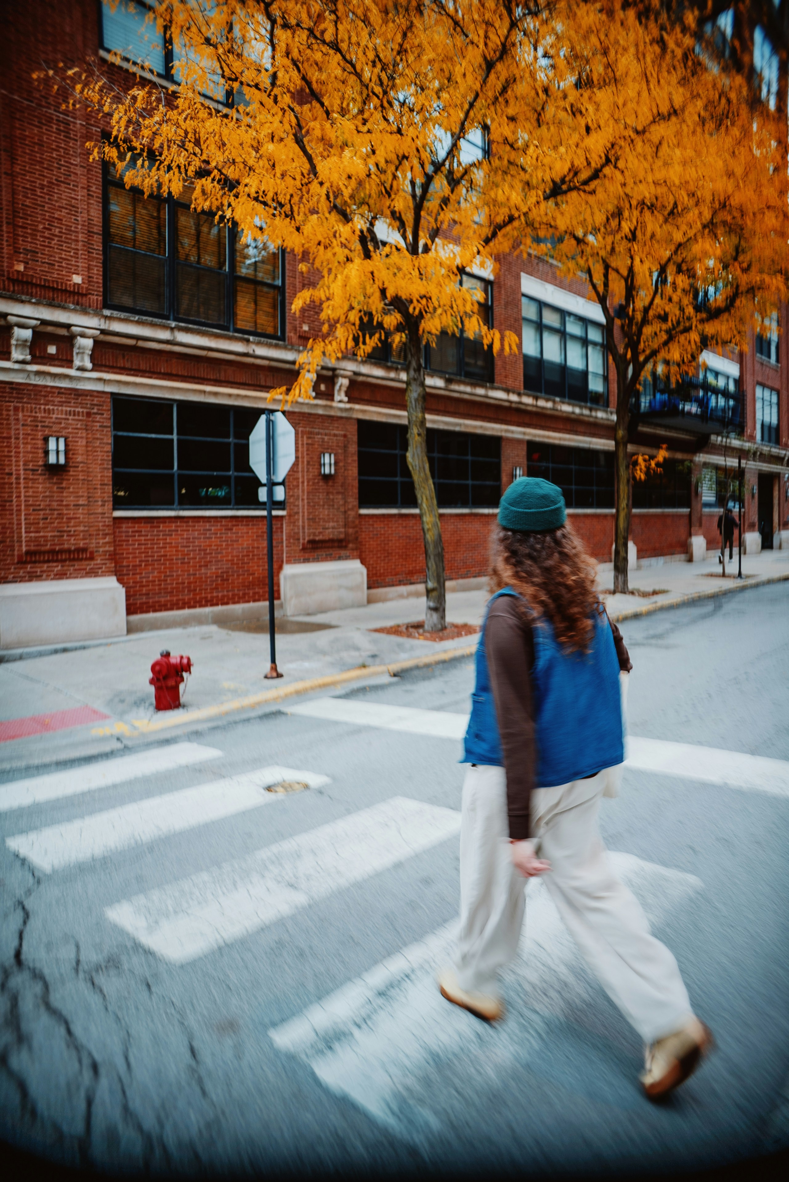 A woman crossing the street in front of a fire hydrant photo – Free ...
