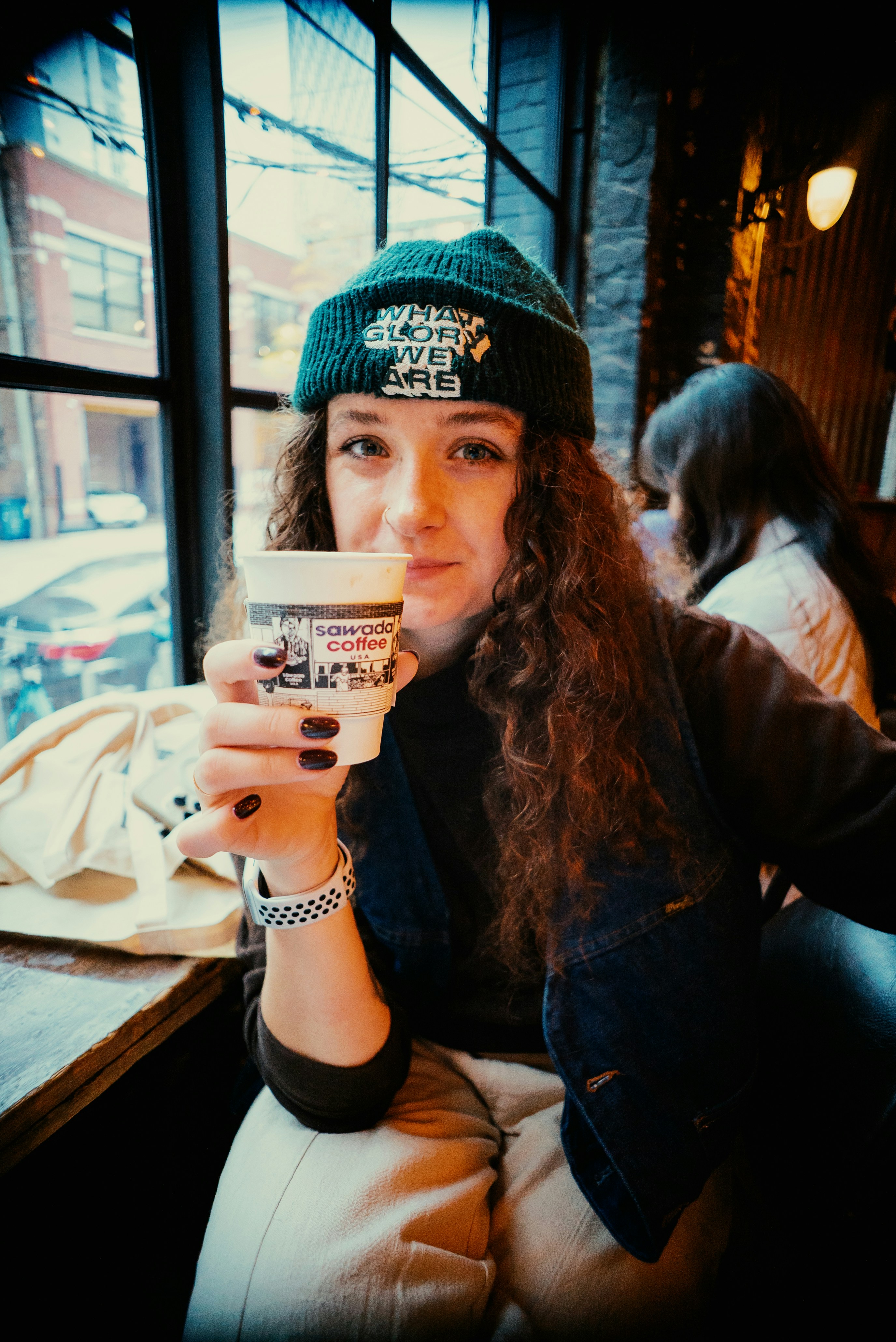 Caffeinated Moment: A Beanie-Clad Smile in a Cozy Café