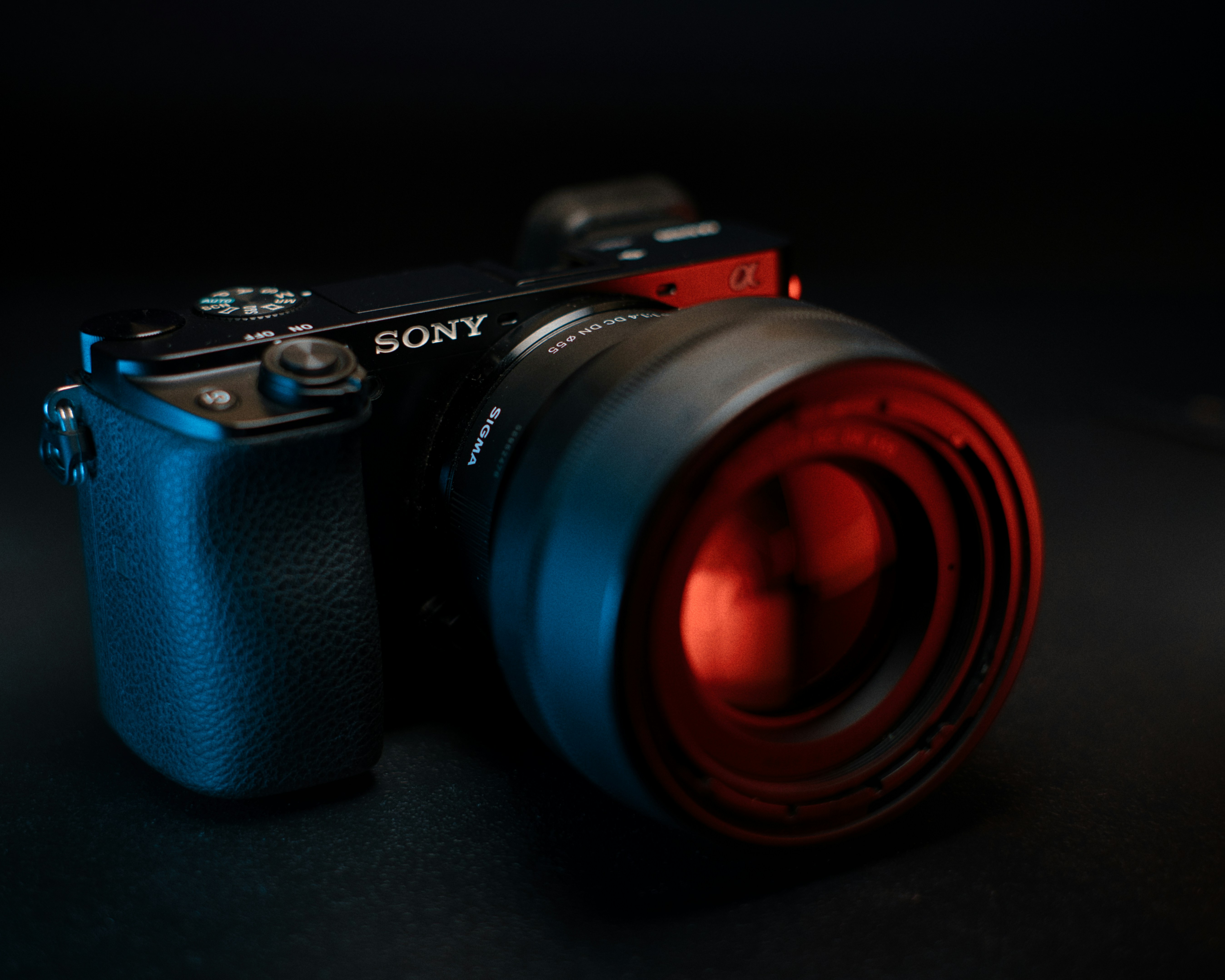 Blue Grip, Red Ring: Studio Close-Up of a Sony Alpha with a Fiery Lens Glow