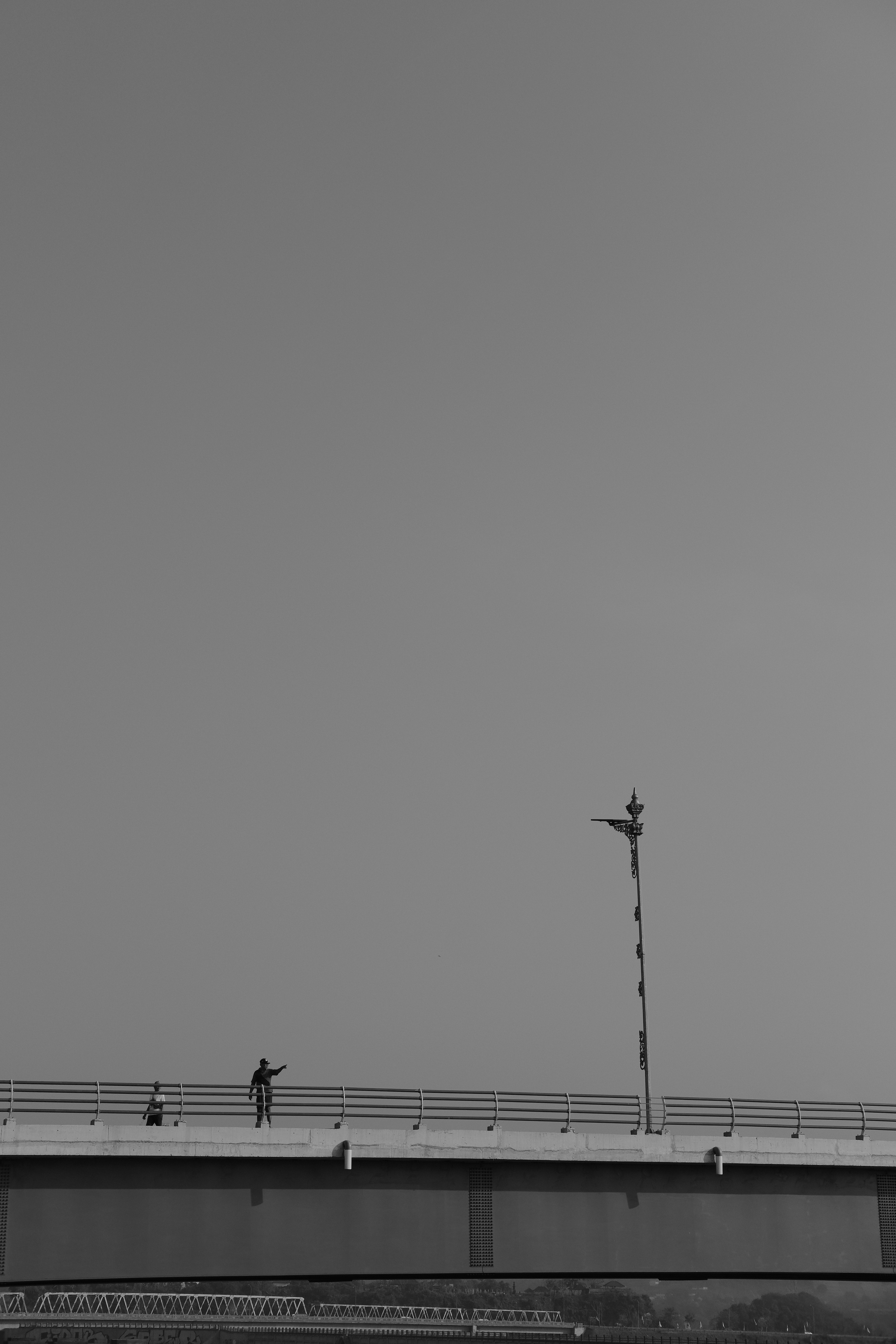 A couple of people standing on top of a bridge photo – Free Wallpaper ...