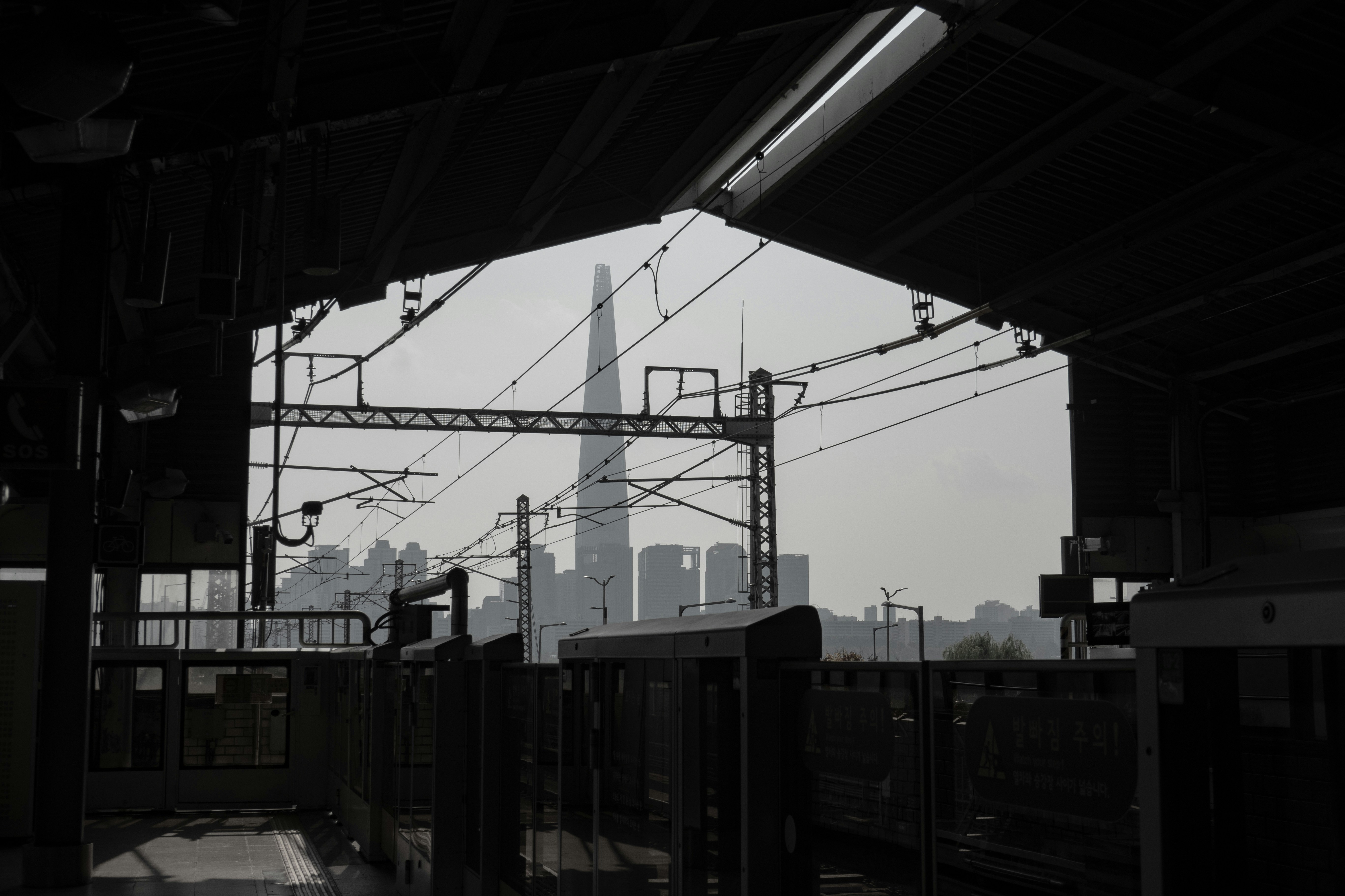 Tracks to the City Edge: A Monochrome Station Framing the Skyline