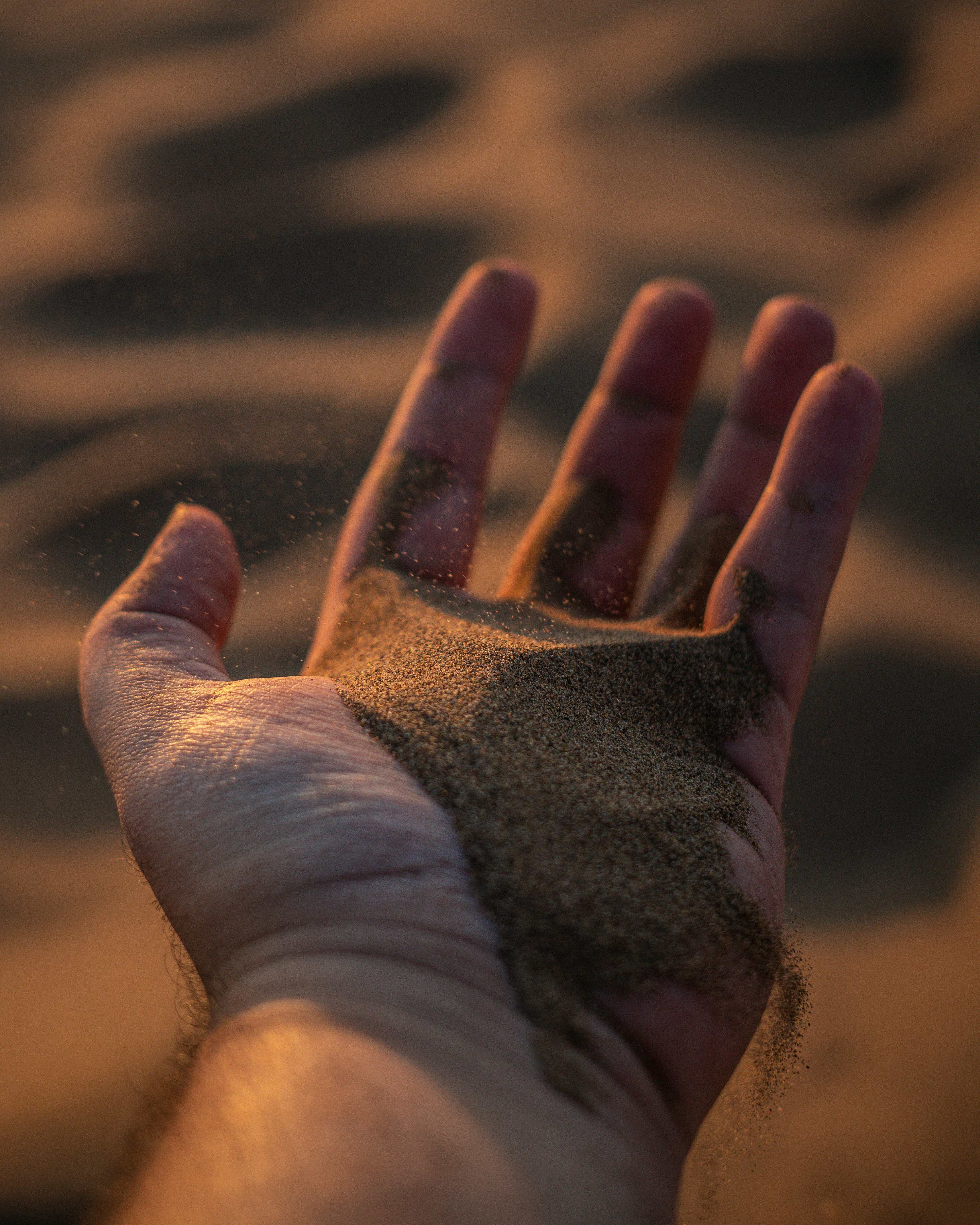 A hand holding sand in the sand on the beach photo – Free Kashan Image ...