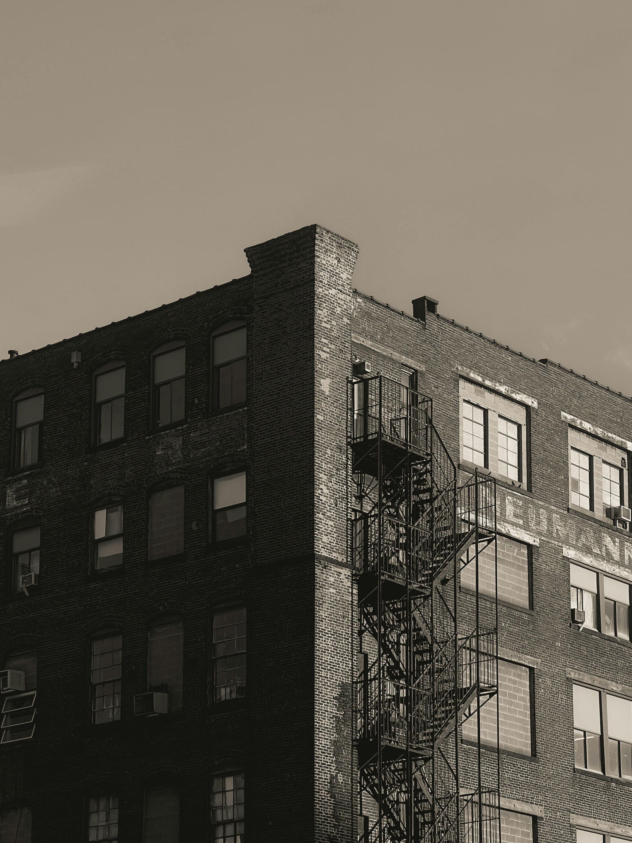 A black and white photo of a building with a fire escape photo – Free ...