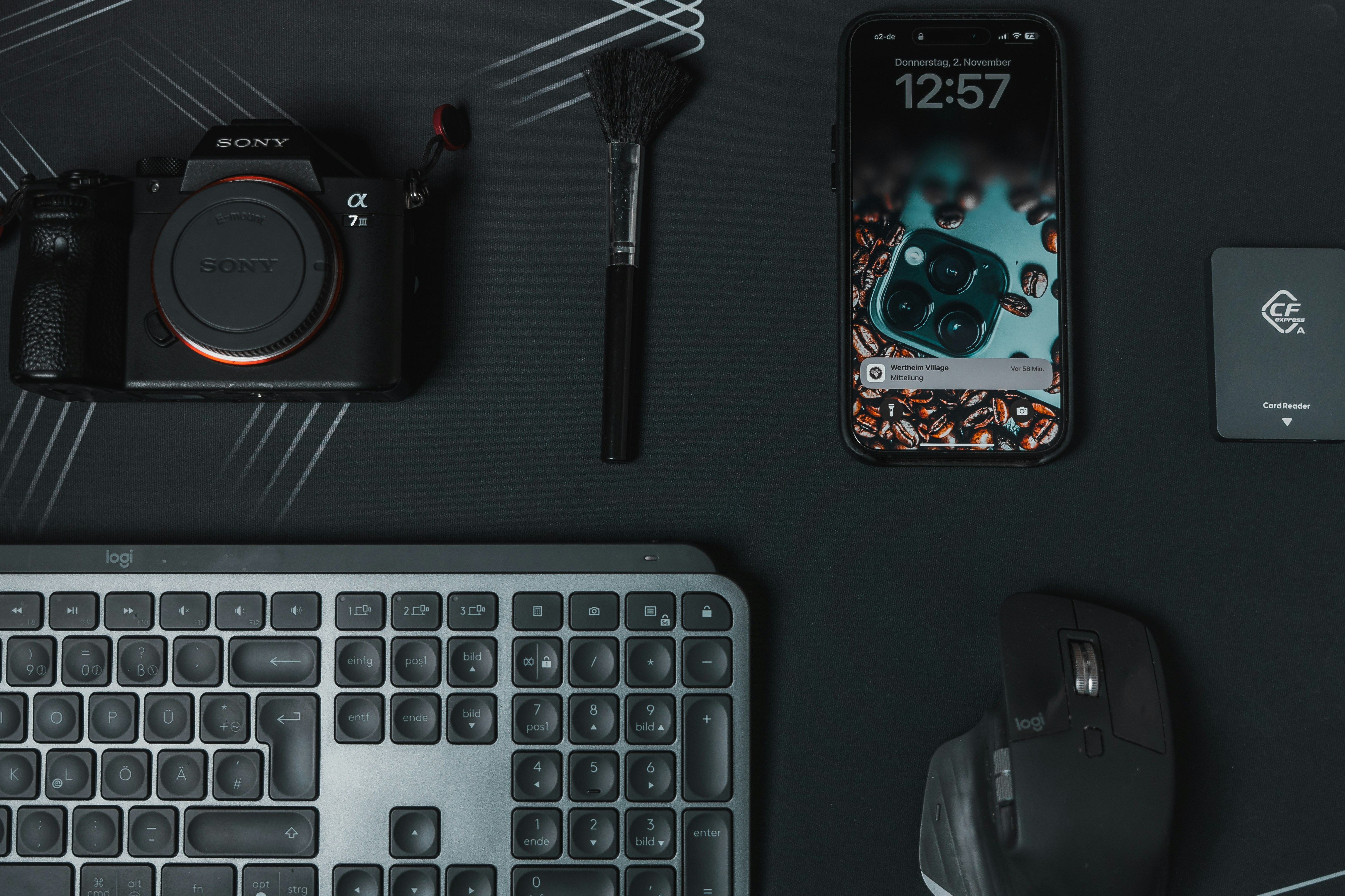 A keyboard, mouse, camera, and cell phone on a desk photo – Free ...