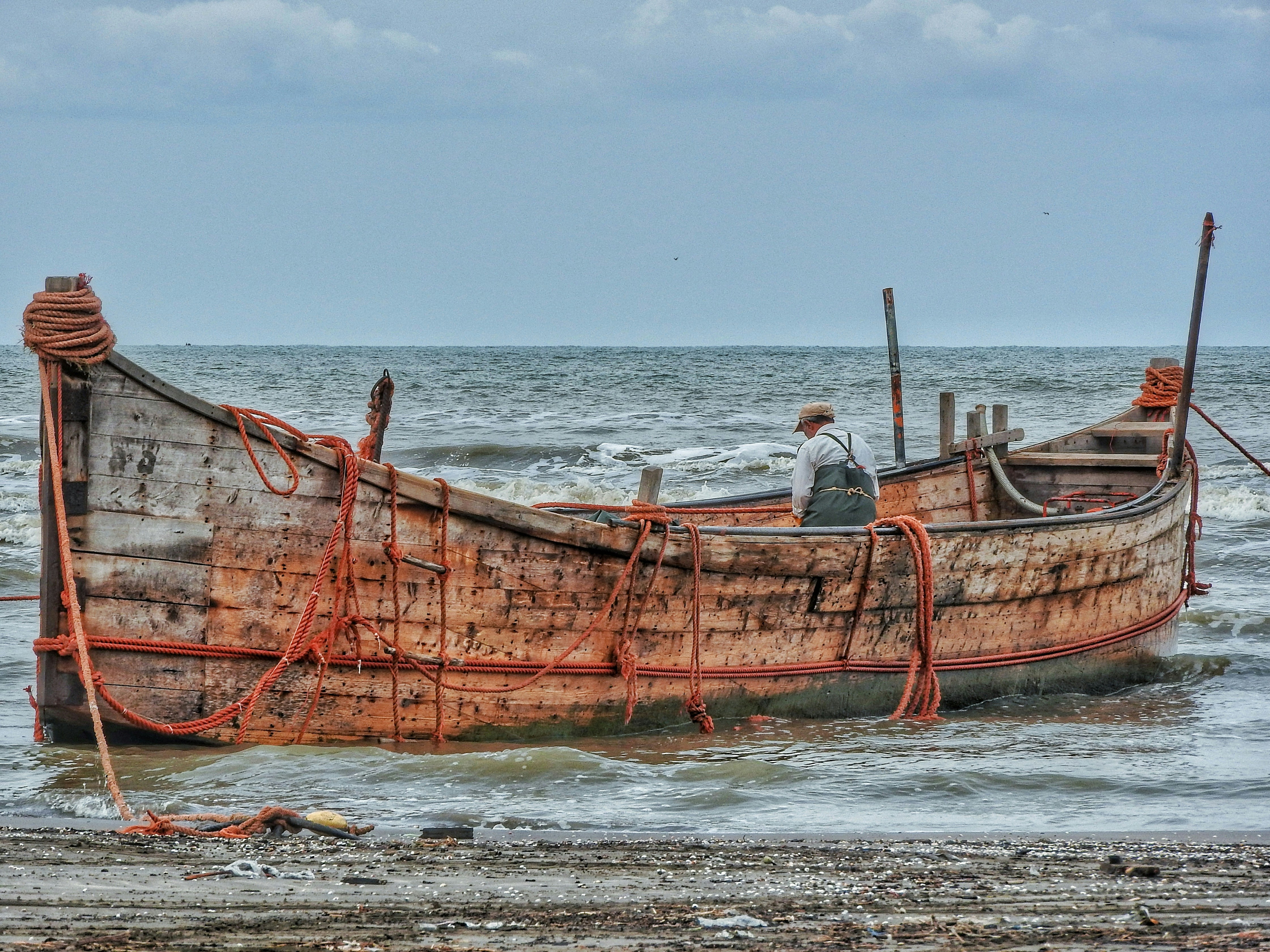 A rusted boat sitting on top of a sandy beach photo – Free Gilān Image ...