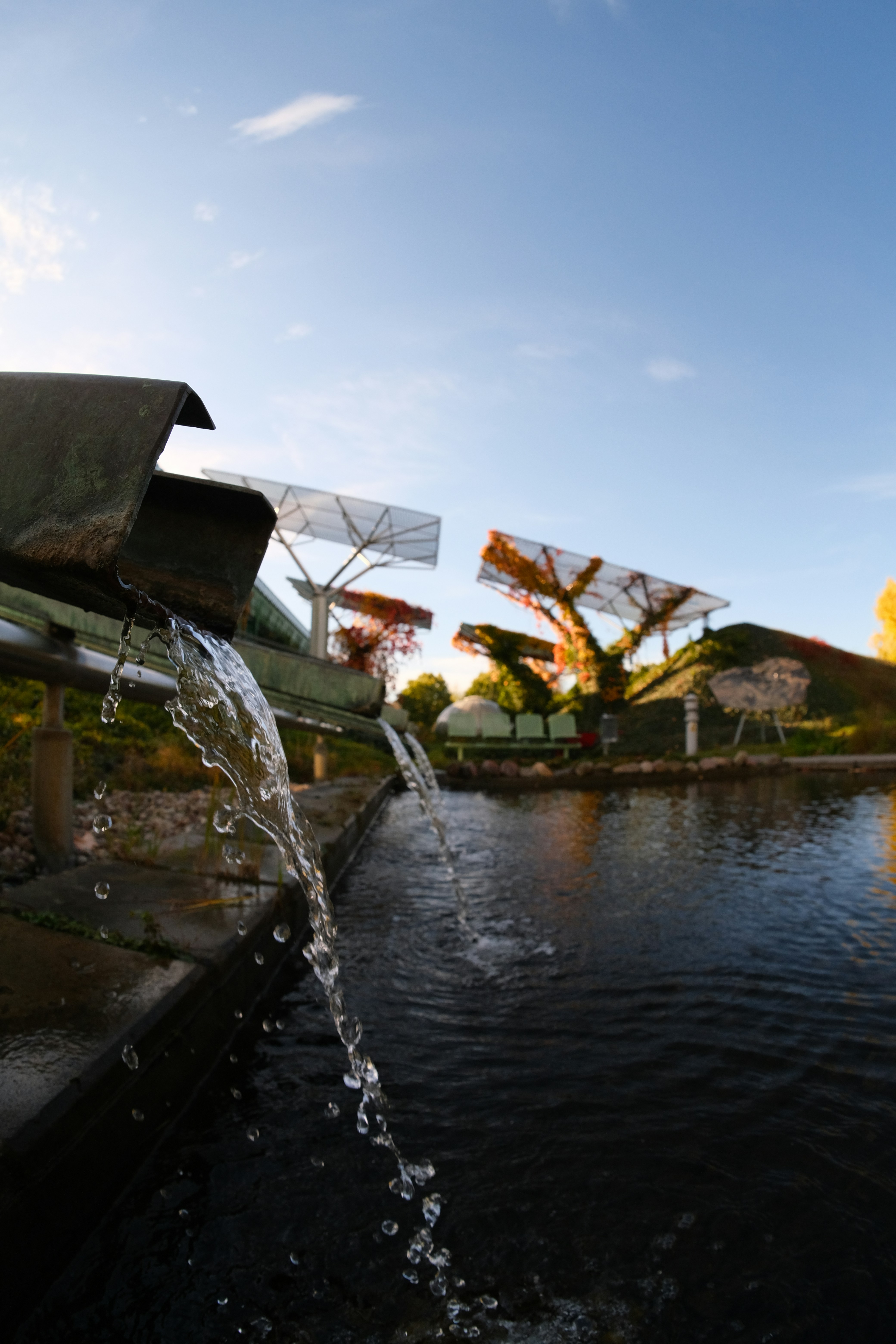 Arcing Waters Over a Tranquil Pool in a Modern Fountain Park