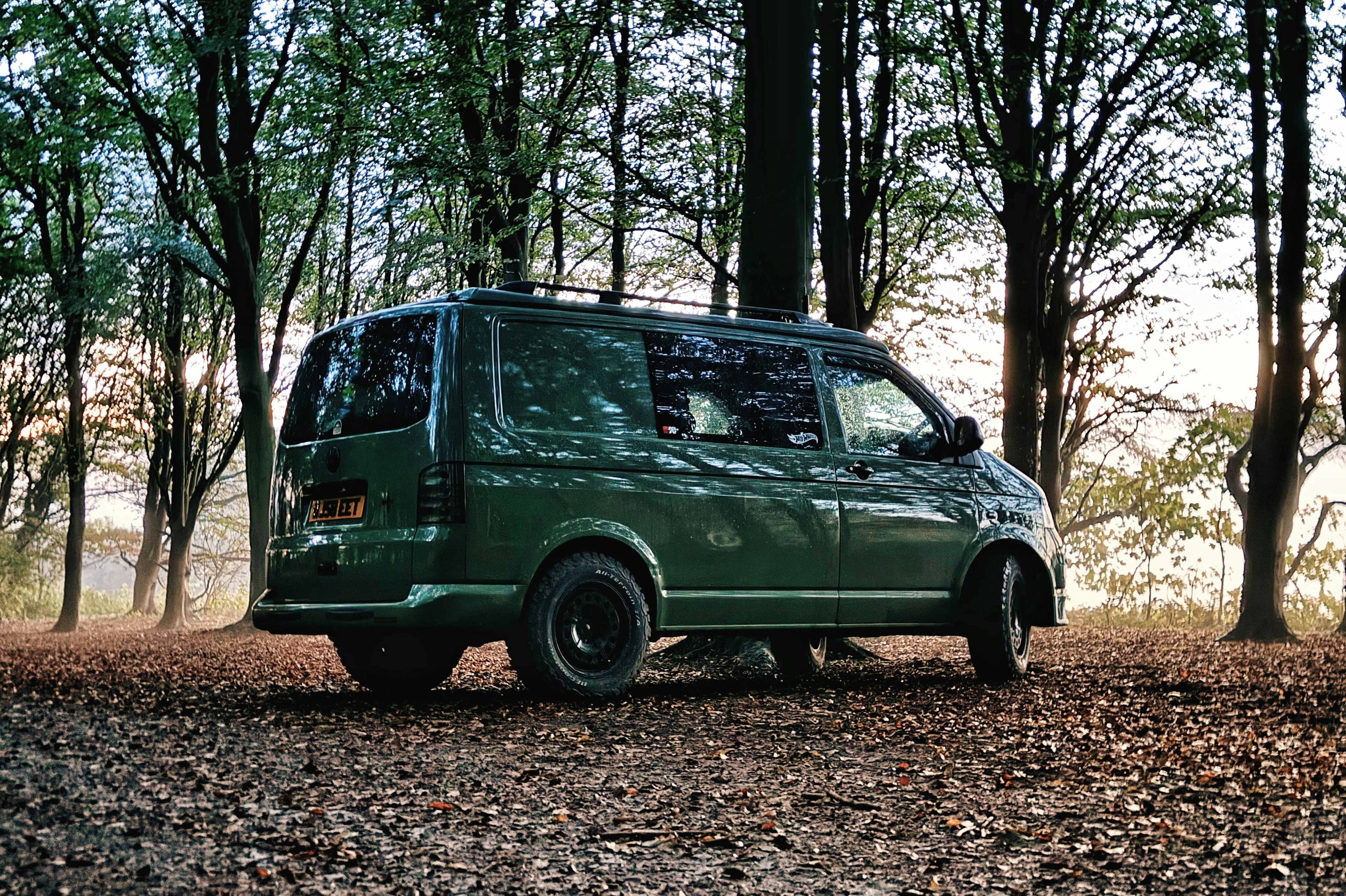 A green van is parked in the woods photo – Free Friston forest Image on ...