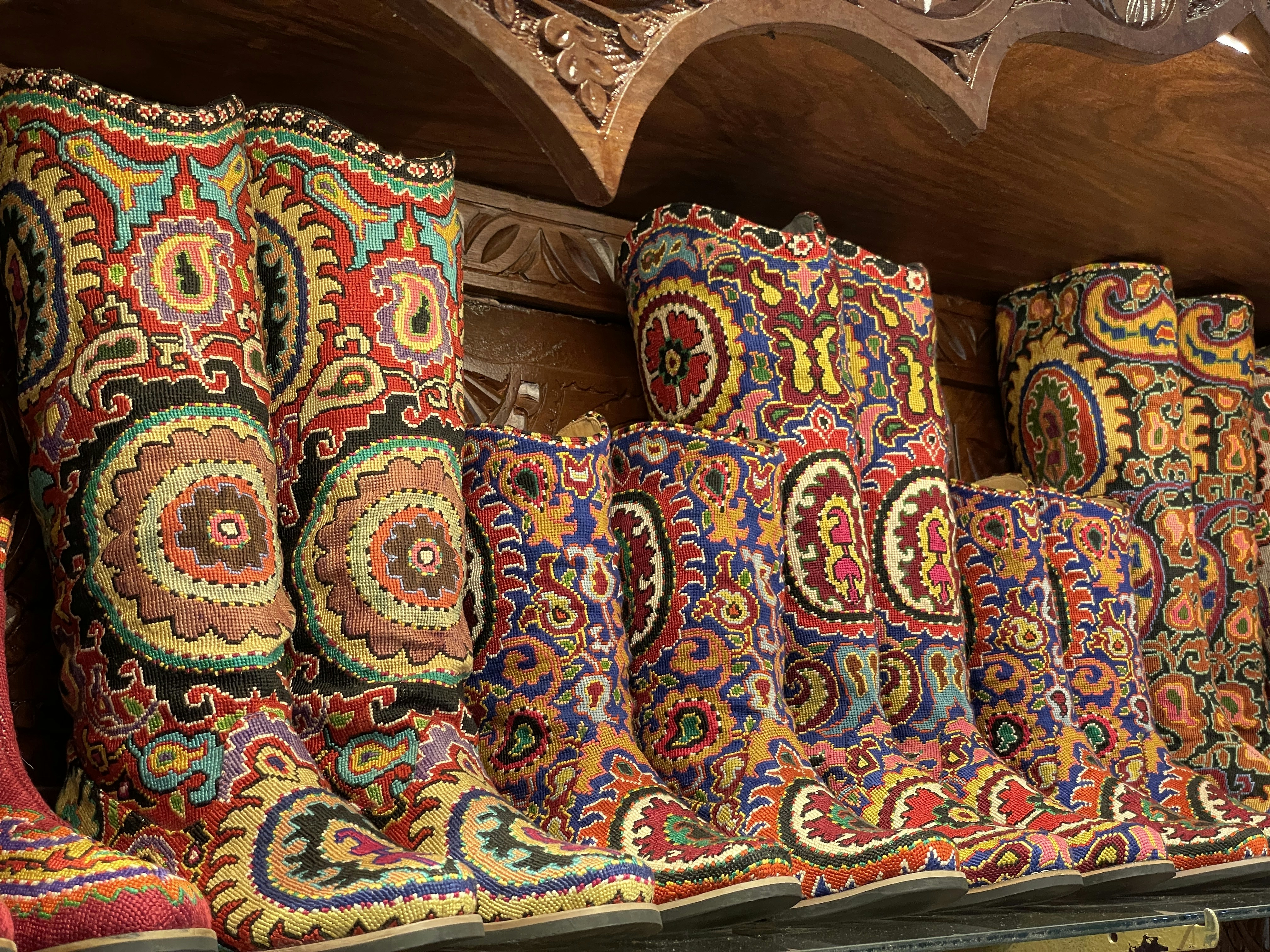 A bunch of colorful rugs sitting on a shelf photo – Free Woman Image on ...