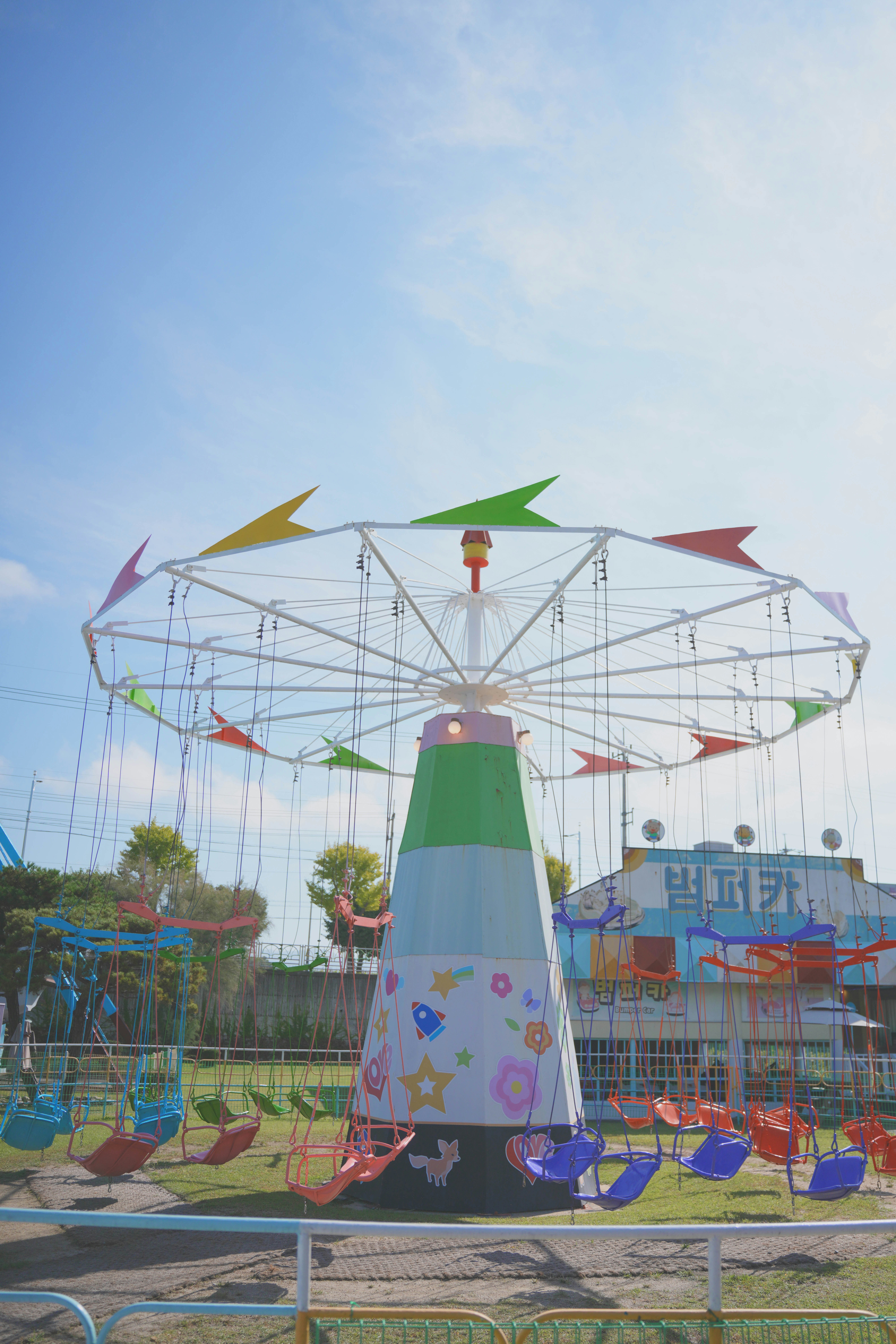 Rainbow Swing Orbit: A Sunlit Carnival Tower