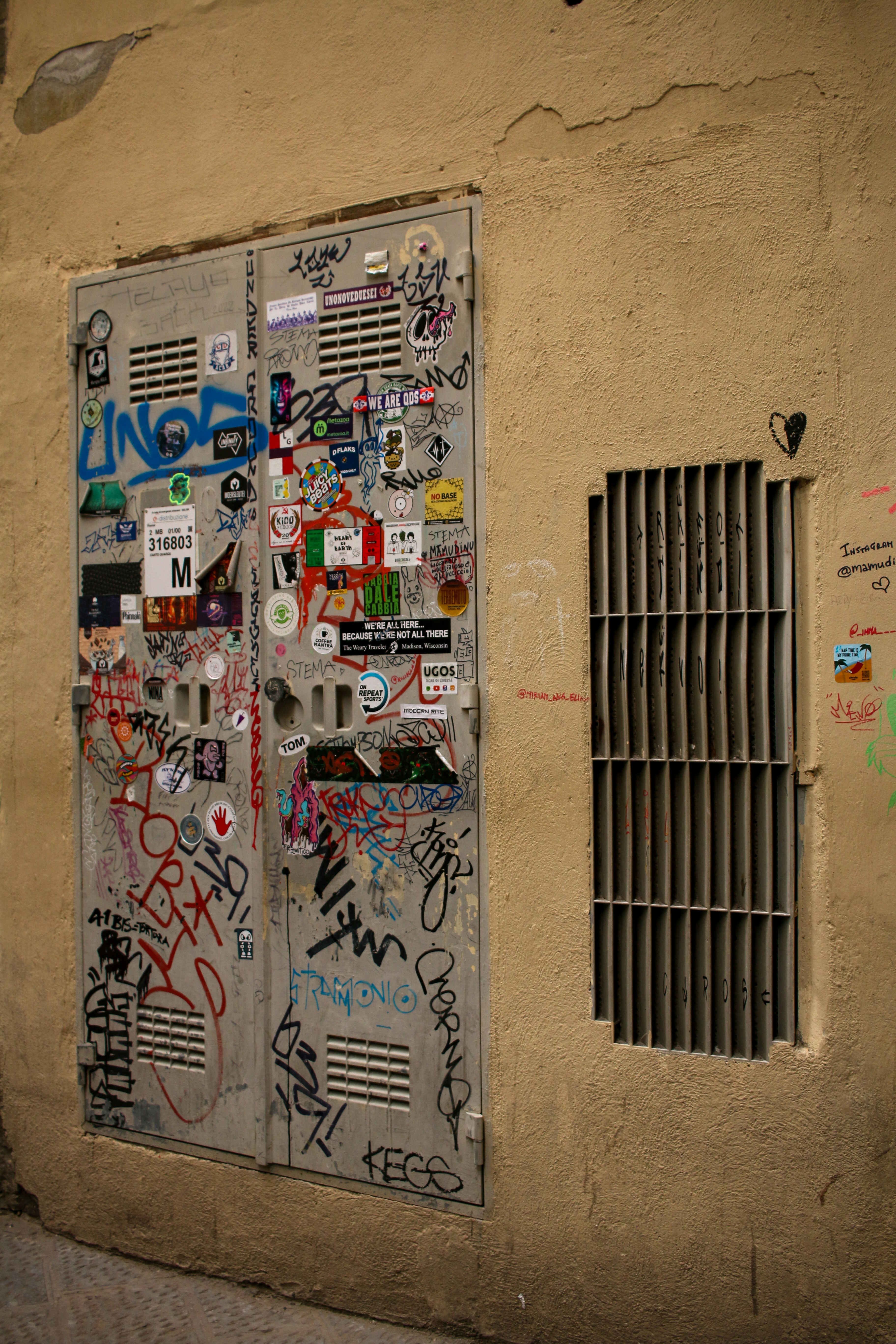 Graffiti-Clad Doorway: A Concrete Wall of Charms and Tags
