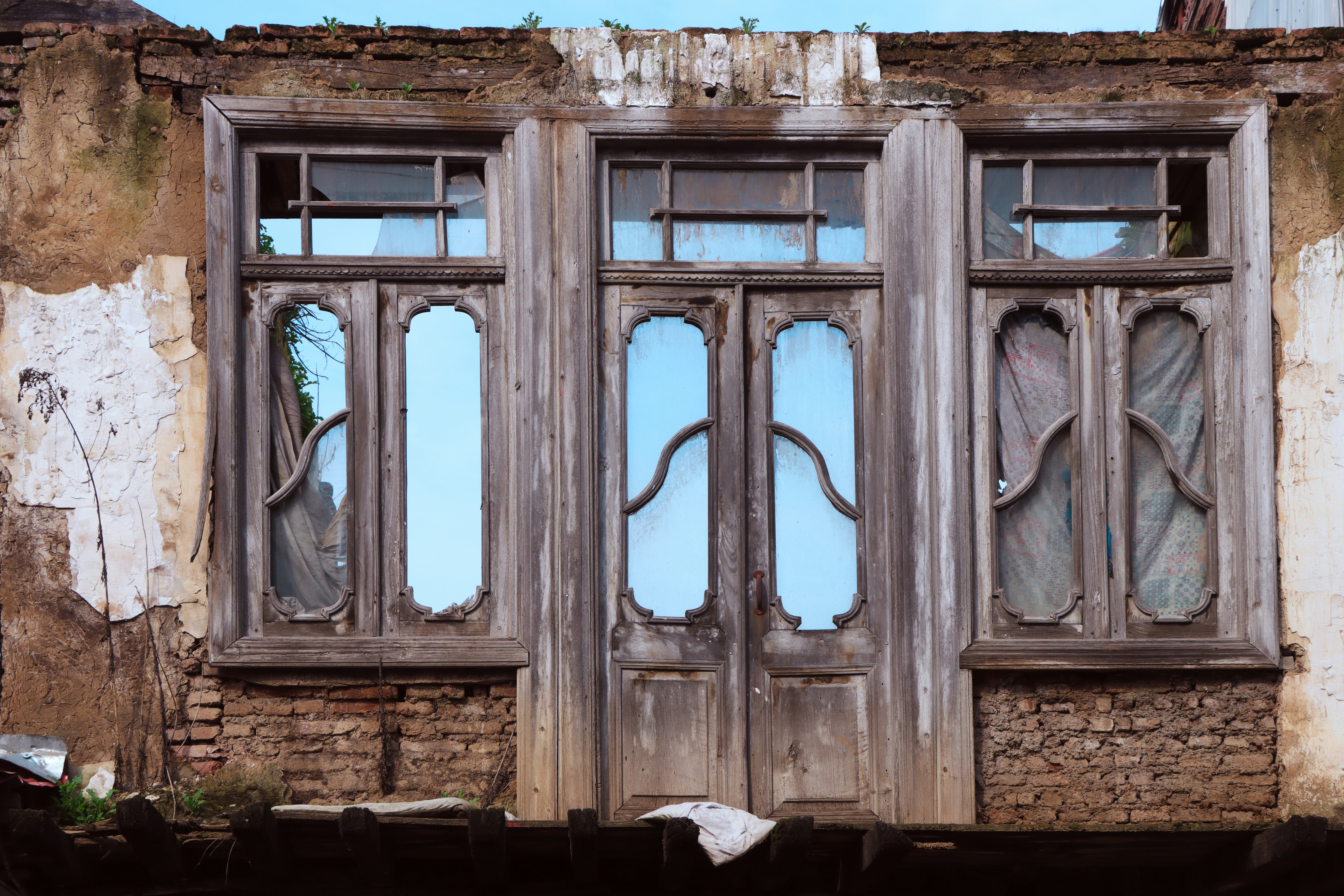 An old building with two windows and a broken curtain photo – Free Home ...