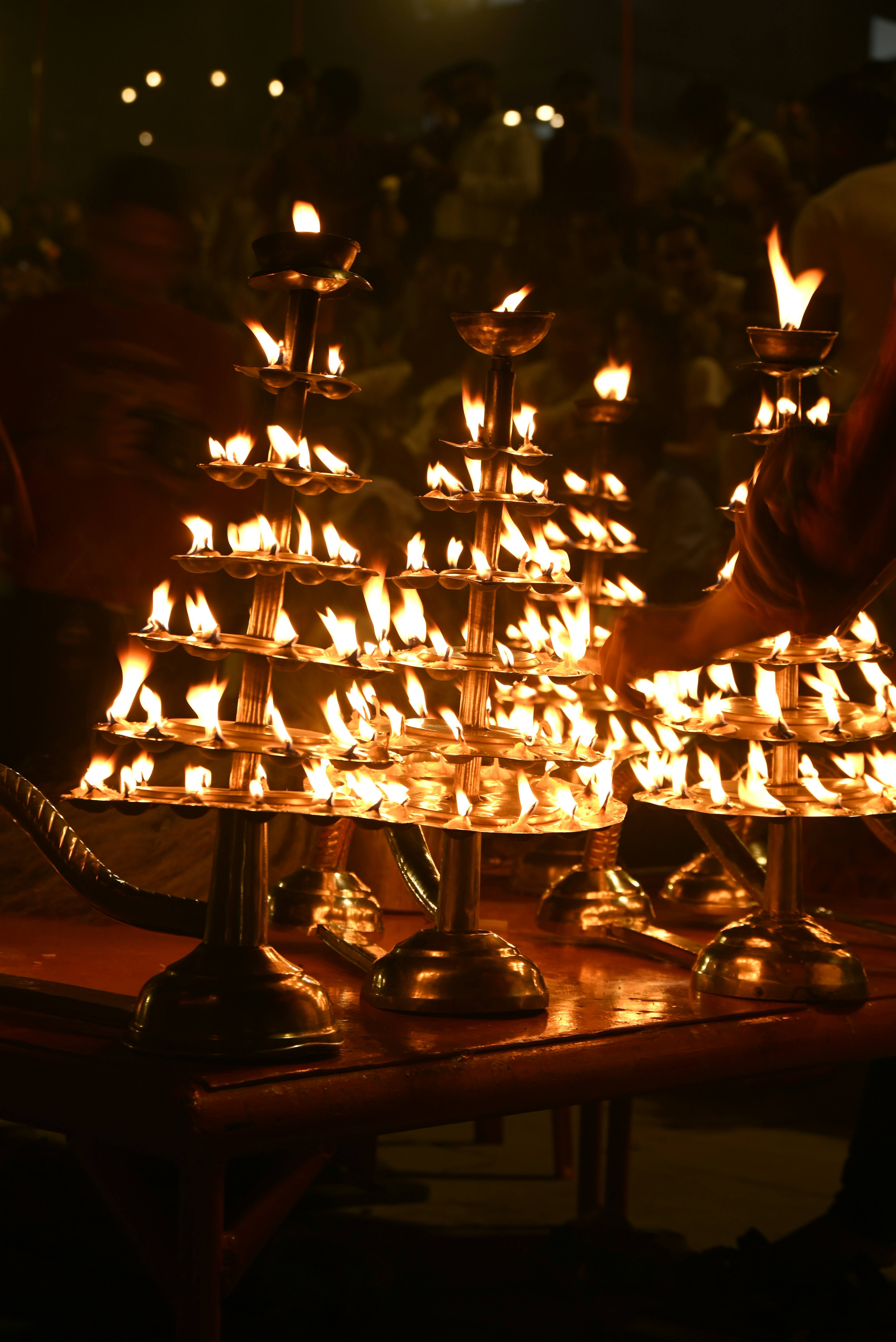 Tiered Flame Towers Spark a Quiet Ritual in a Dim Hall