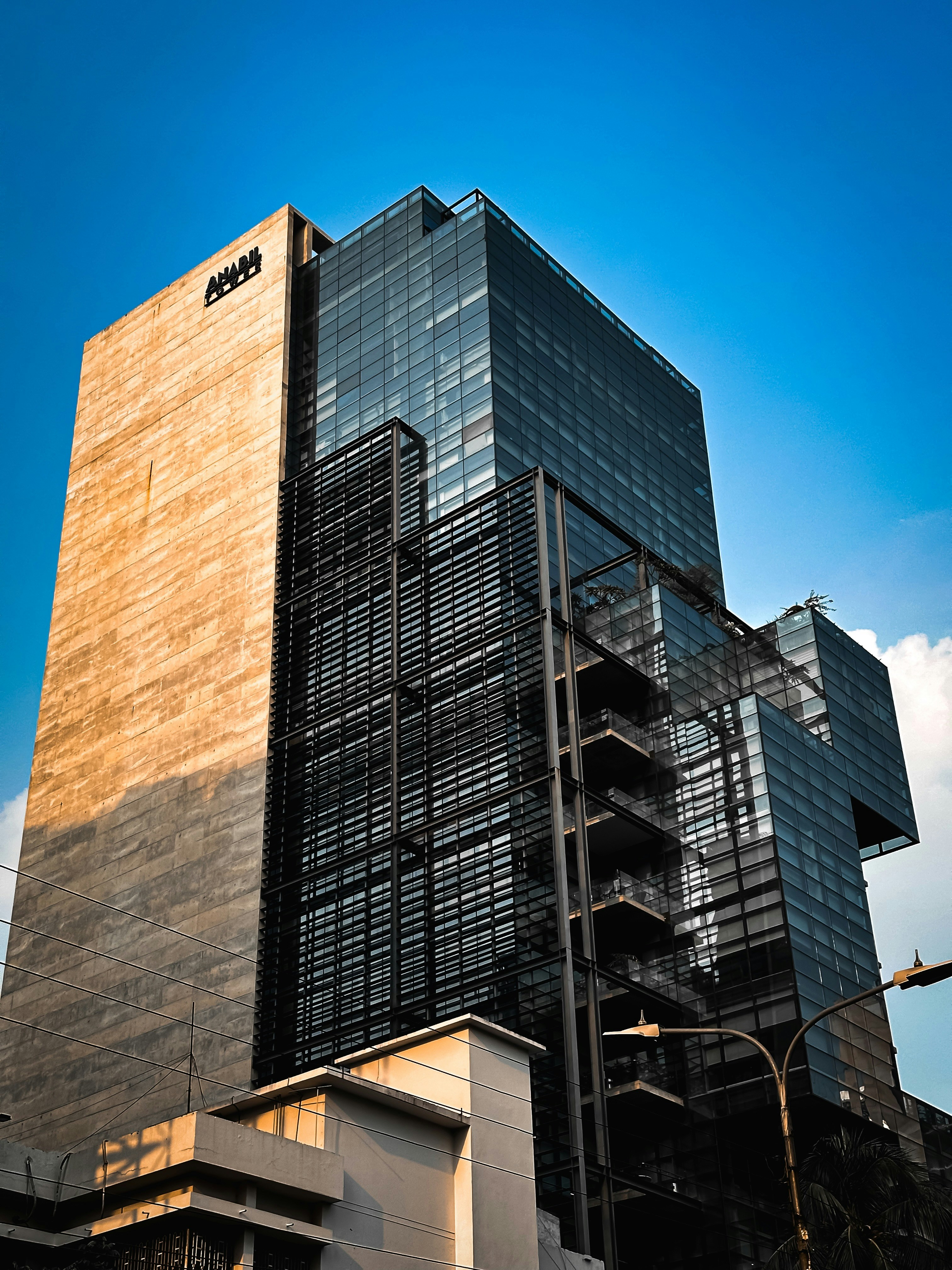 Lattice of Light: Sunlit Glass-and-Steel Tower Reaching Toward a Clear Sky