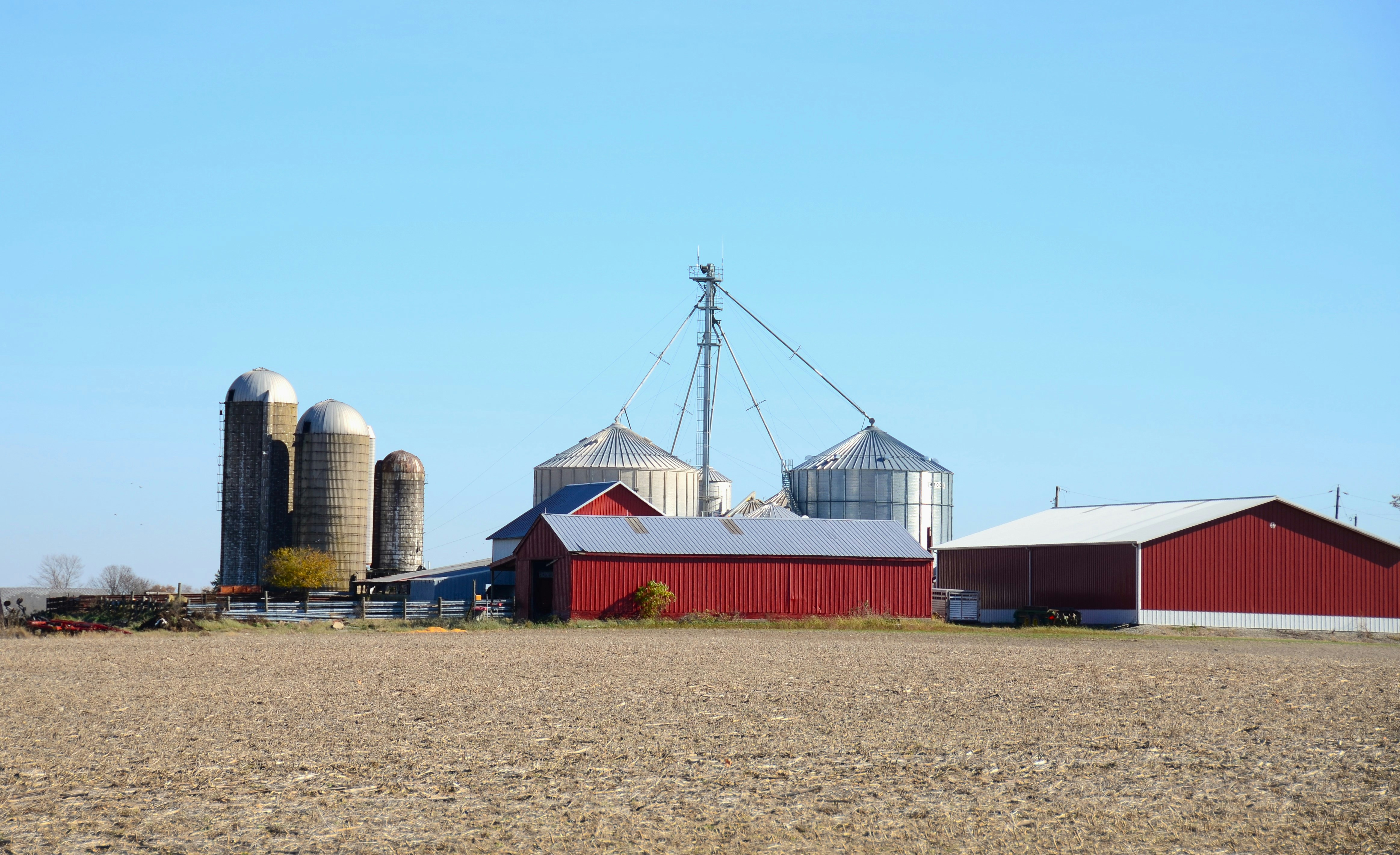 A farm with a red barn and silos photo – Free Nature Image on Unsplash