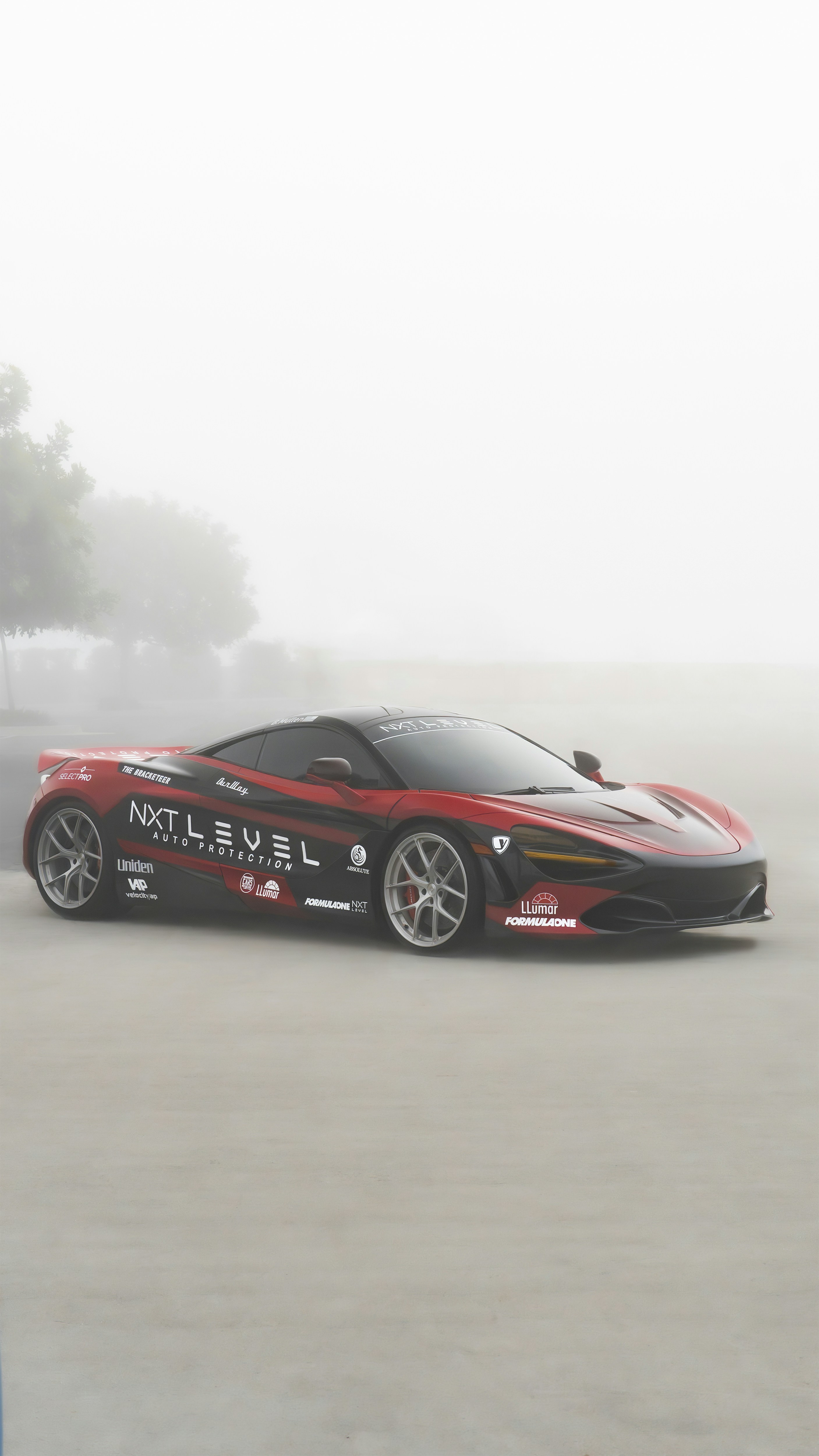 Foto Un coche deportivo negro y rojo conduciendo por una calle – Imagen ...