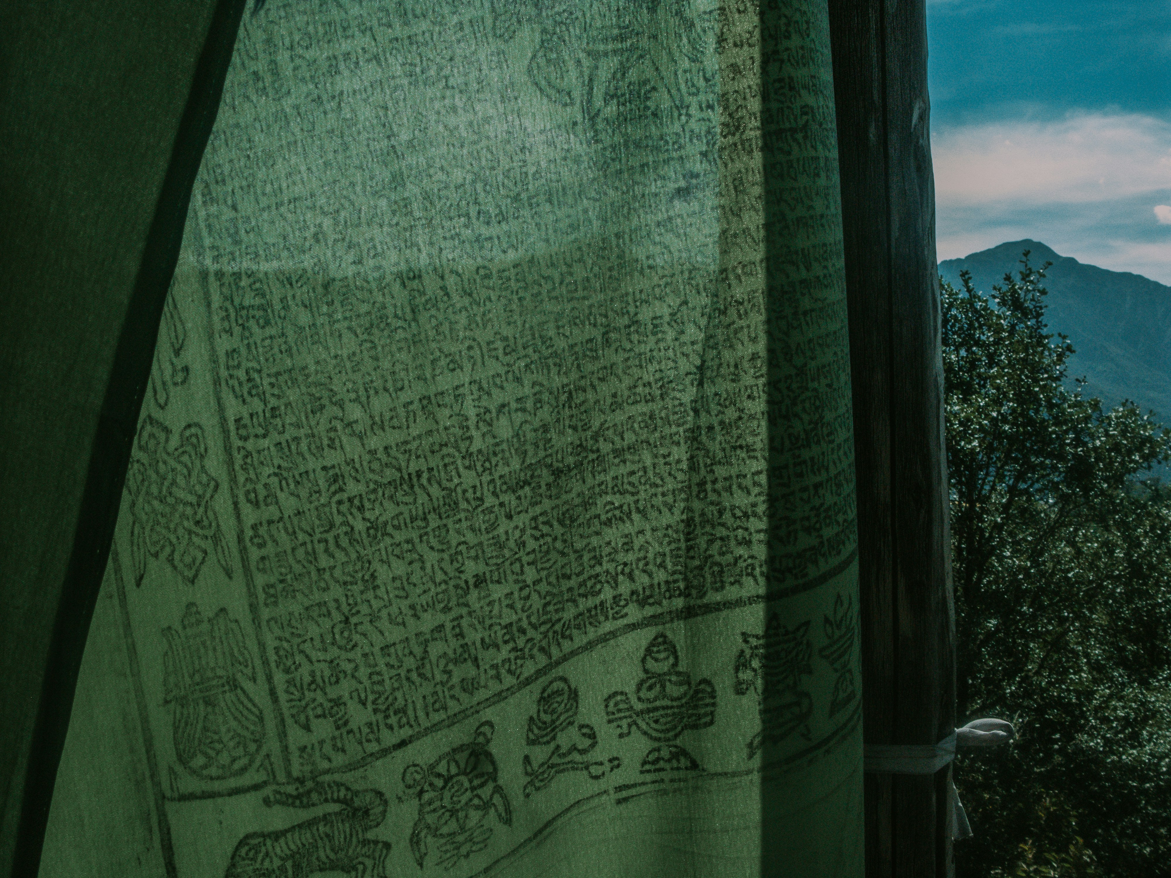 Verdant Tent Fabric Framing a Quiet Mountain Vista
