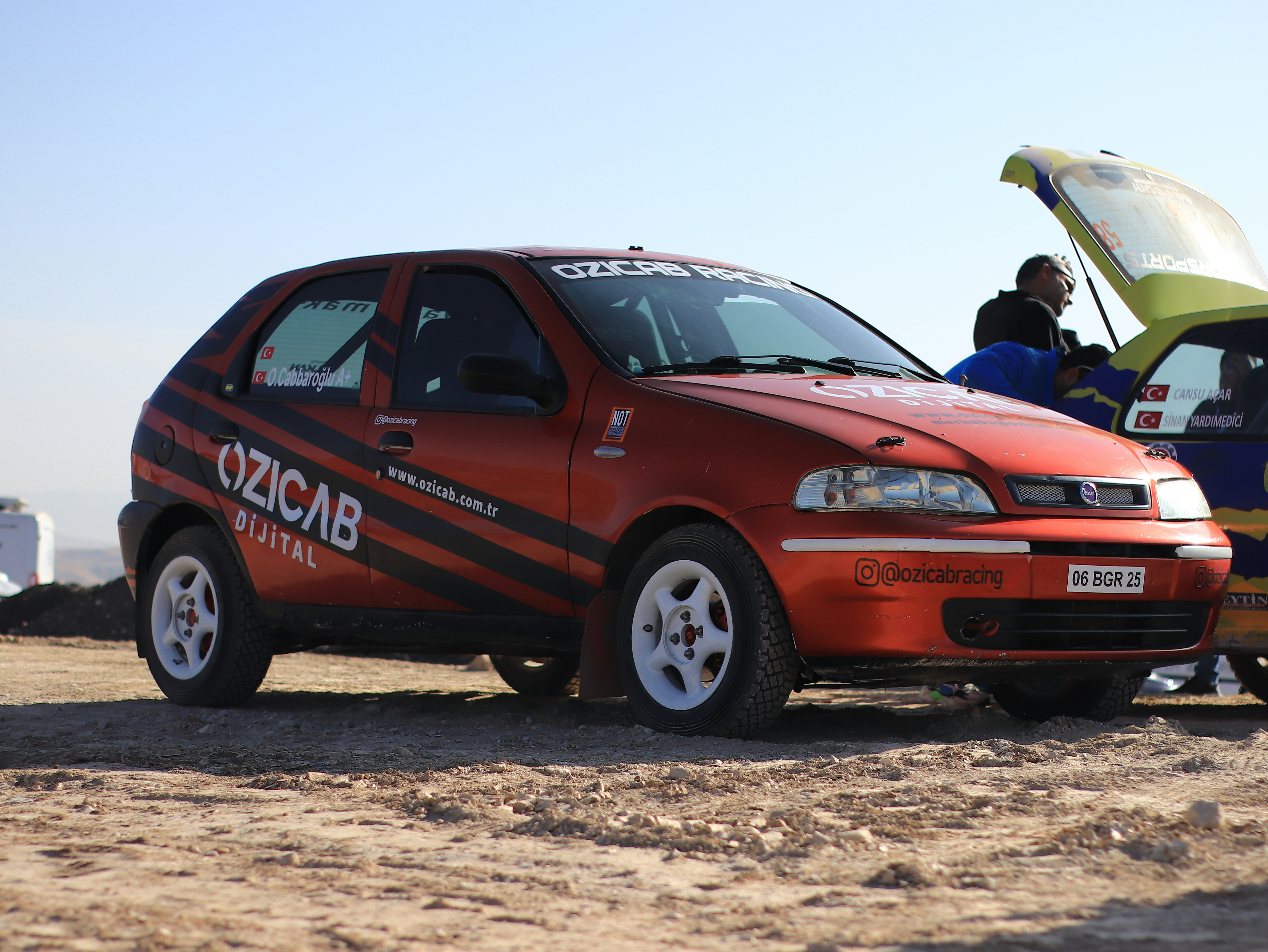 Coastal Pit Stop: Red Rally Hatchback with Sponsor Decals