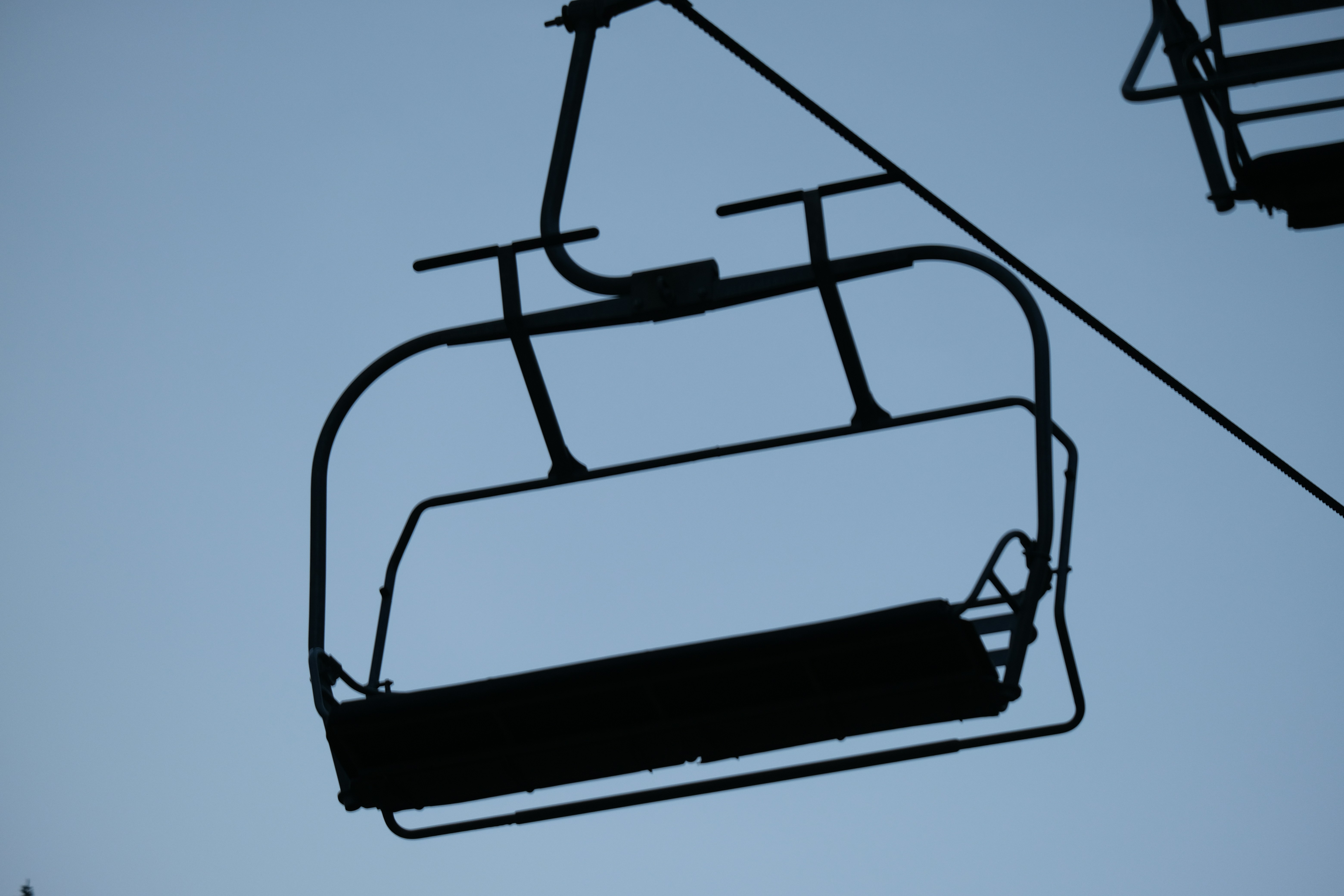 Lift Silhouette: An Empty Chair Against a Clear Blue Sky