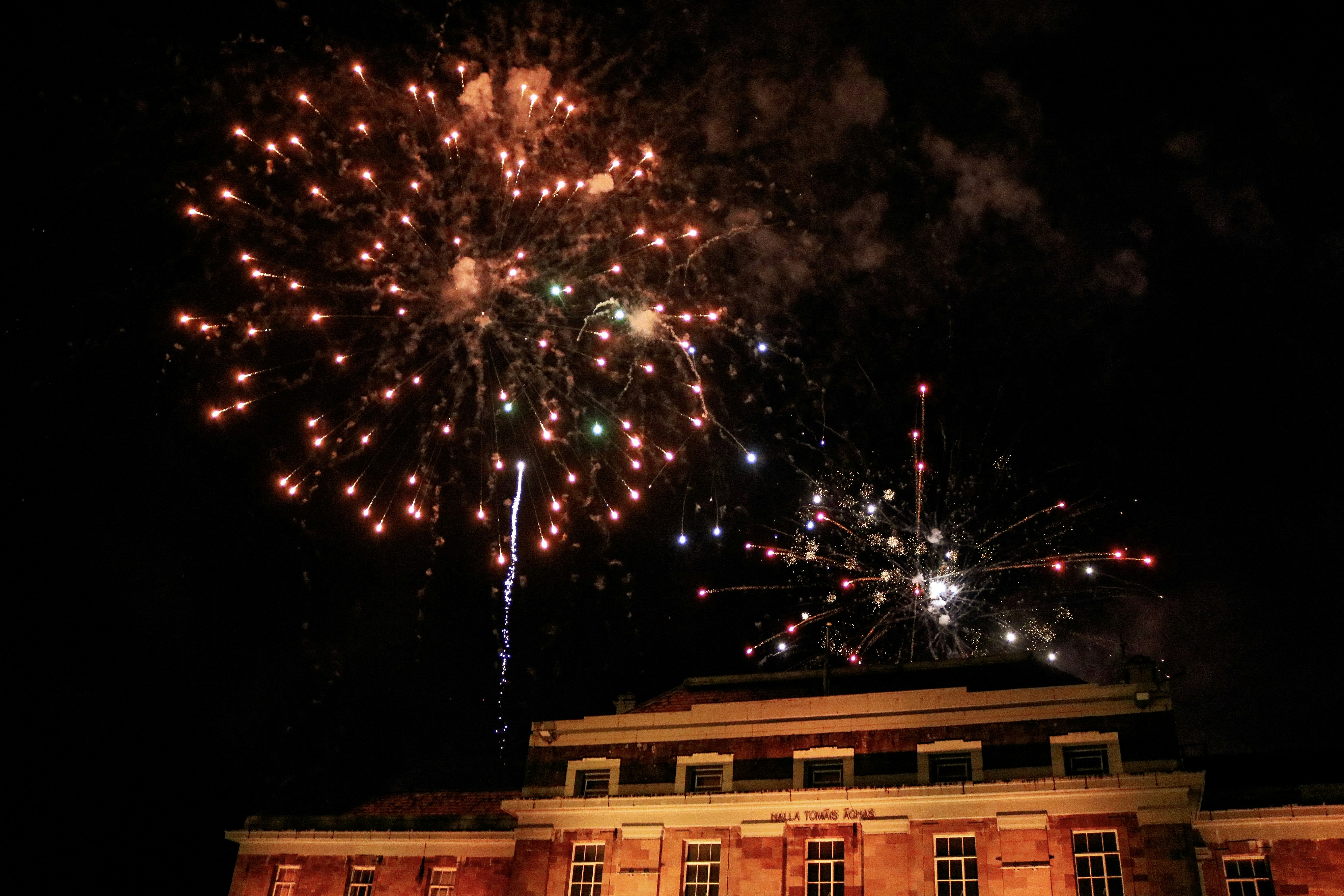 Pyrotechnic Veil Over a Classical Brick Facade at Night