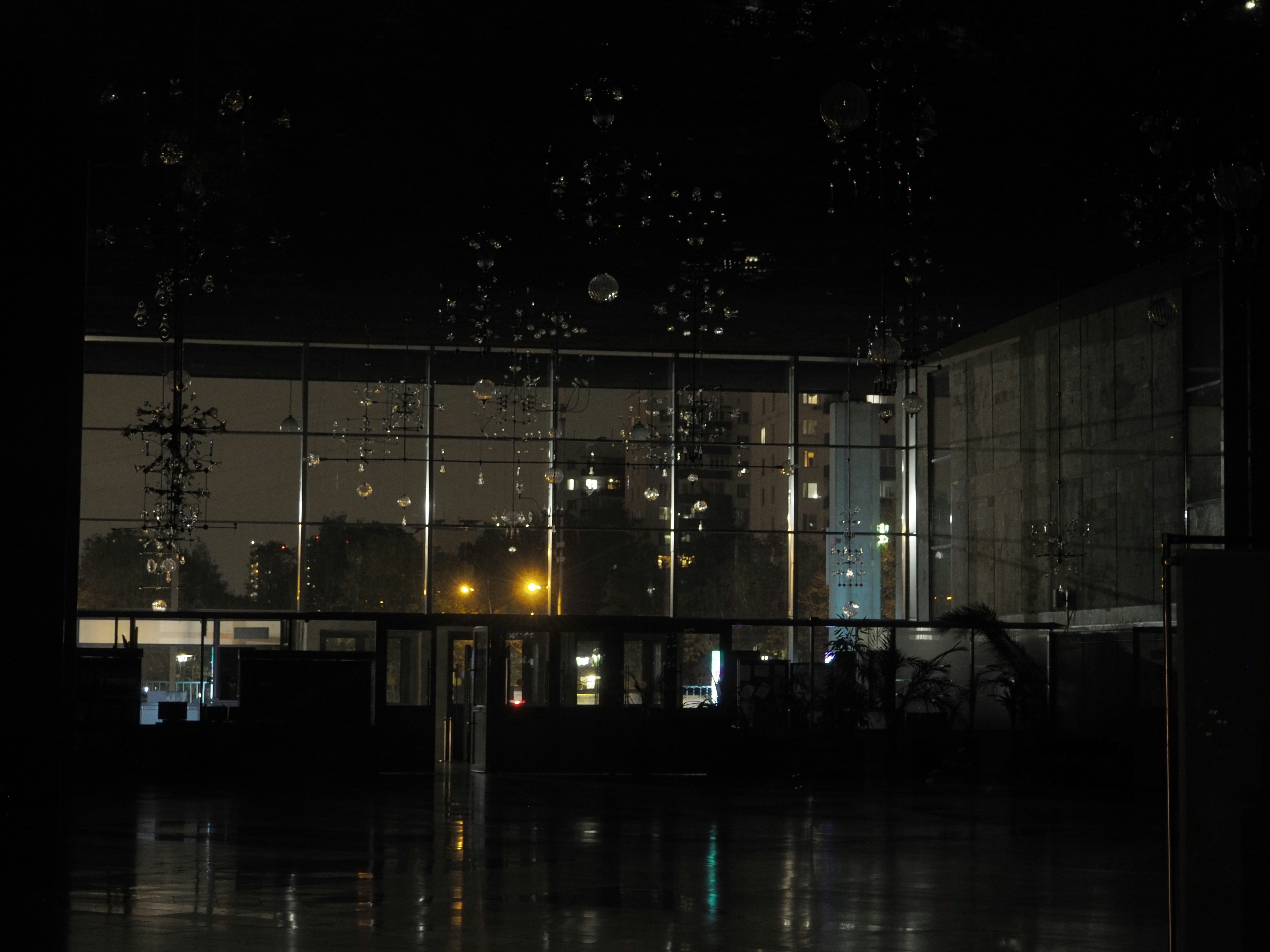 Glass-walled building reflecting city lights at night.