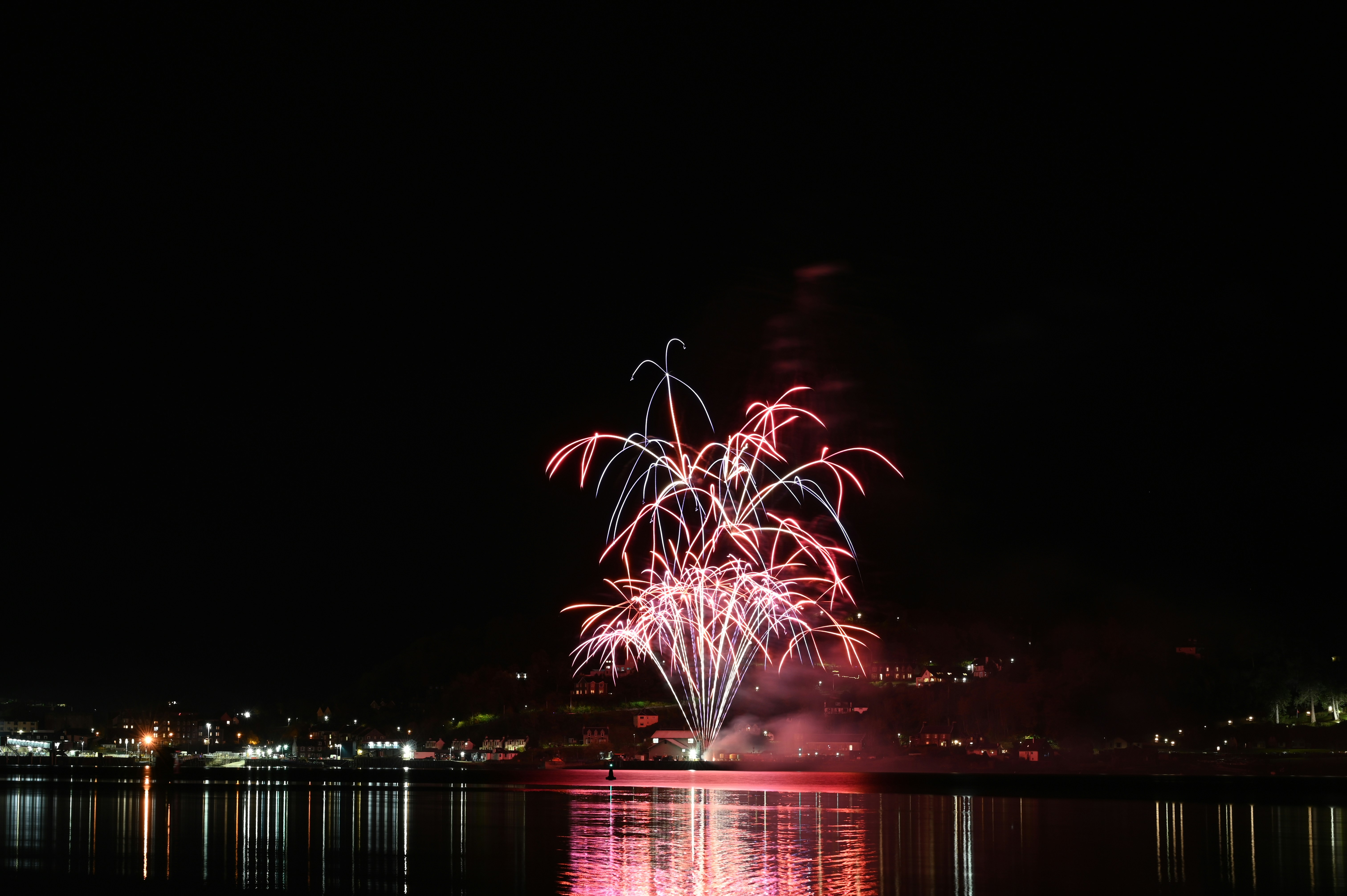 A fireworks display is lit up in the night sky photo – Free Fireworks ...