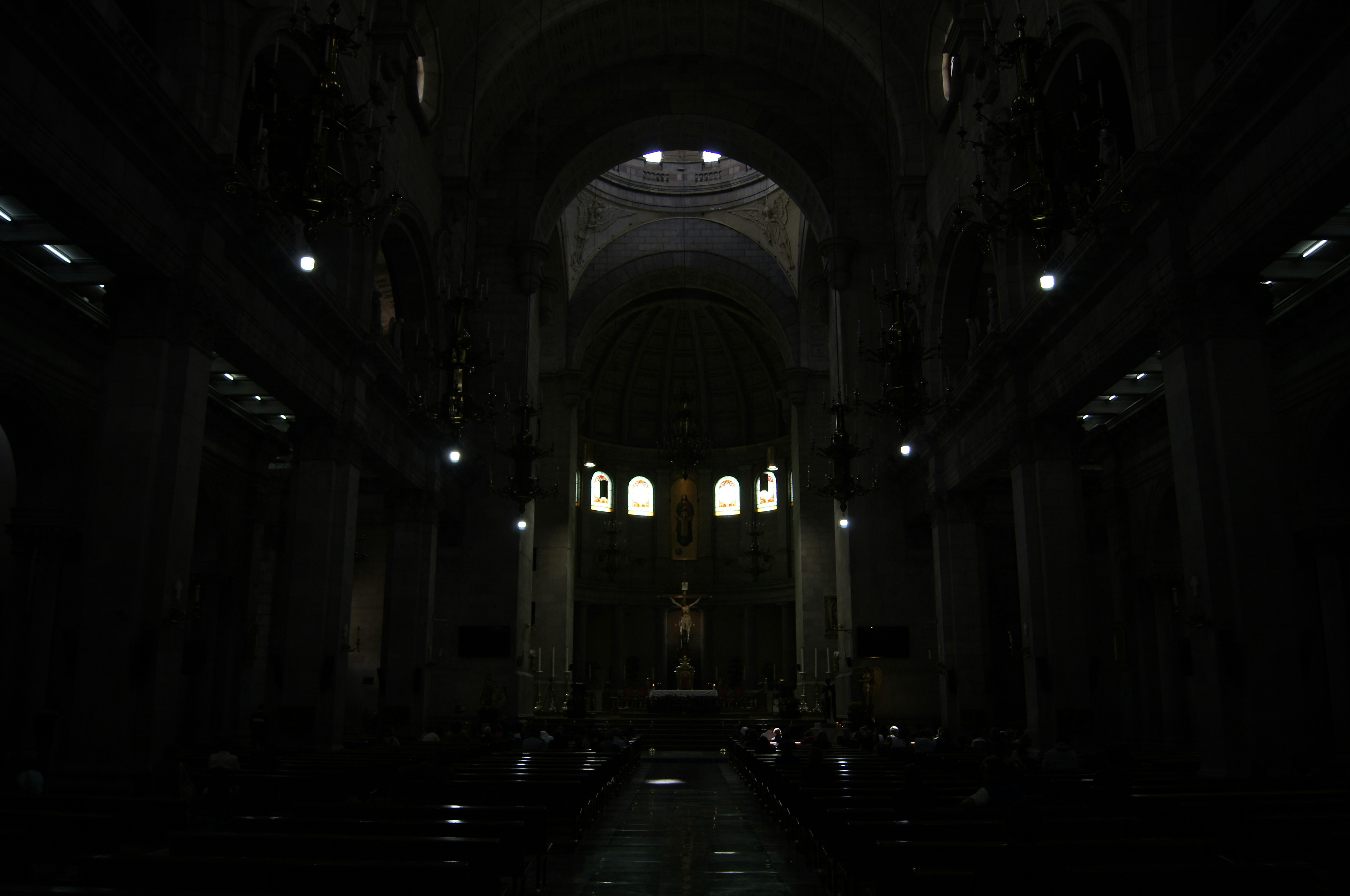 A dimly lit church with pews and stained glass windows photo – Free ...