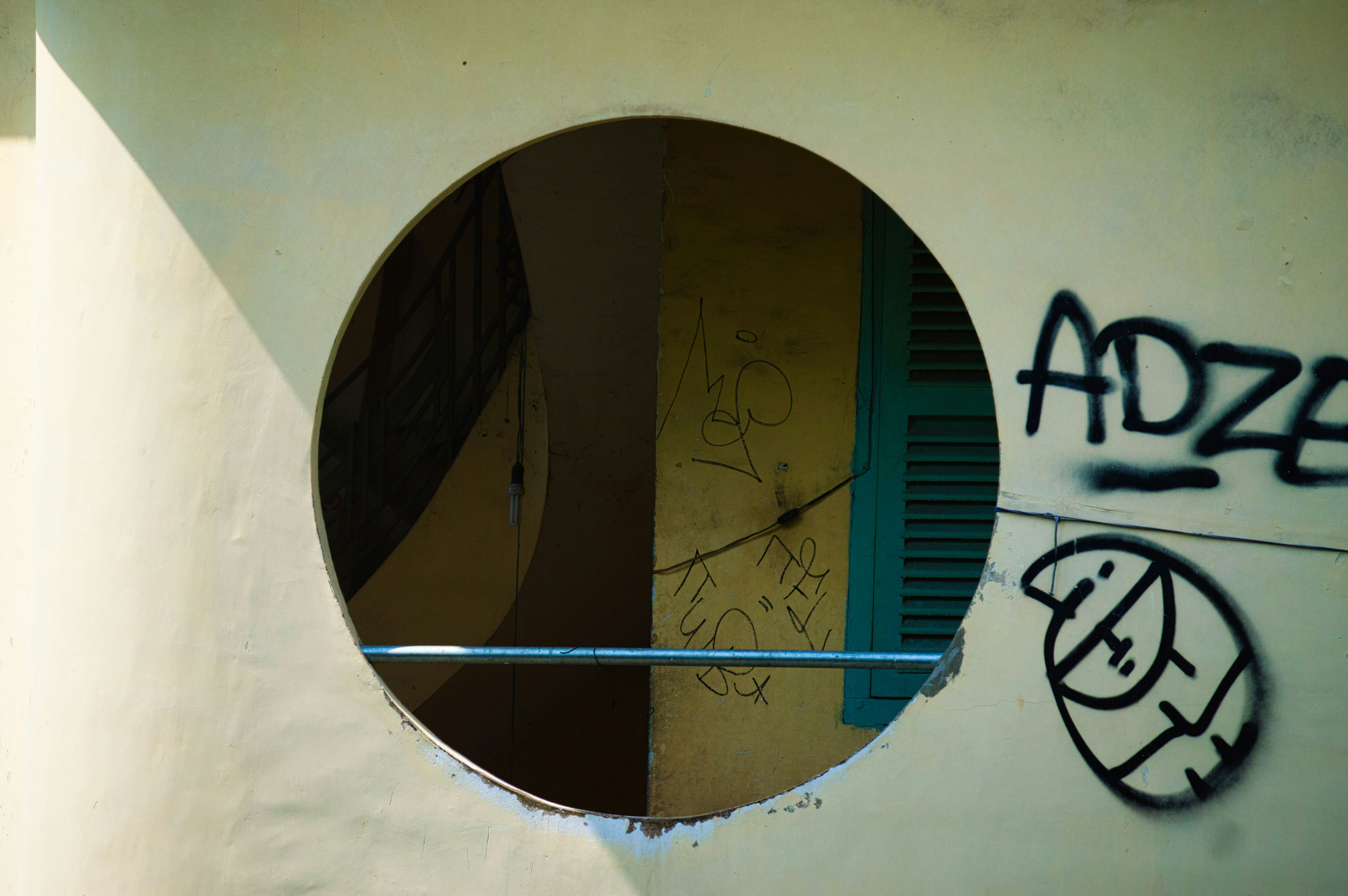 Circular Portal: Graffiti, Light, and a Glimpse of a Stairwell