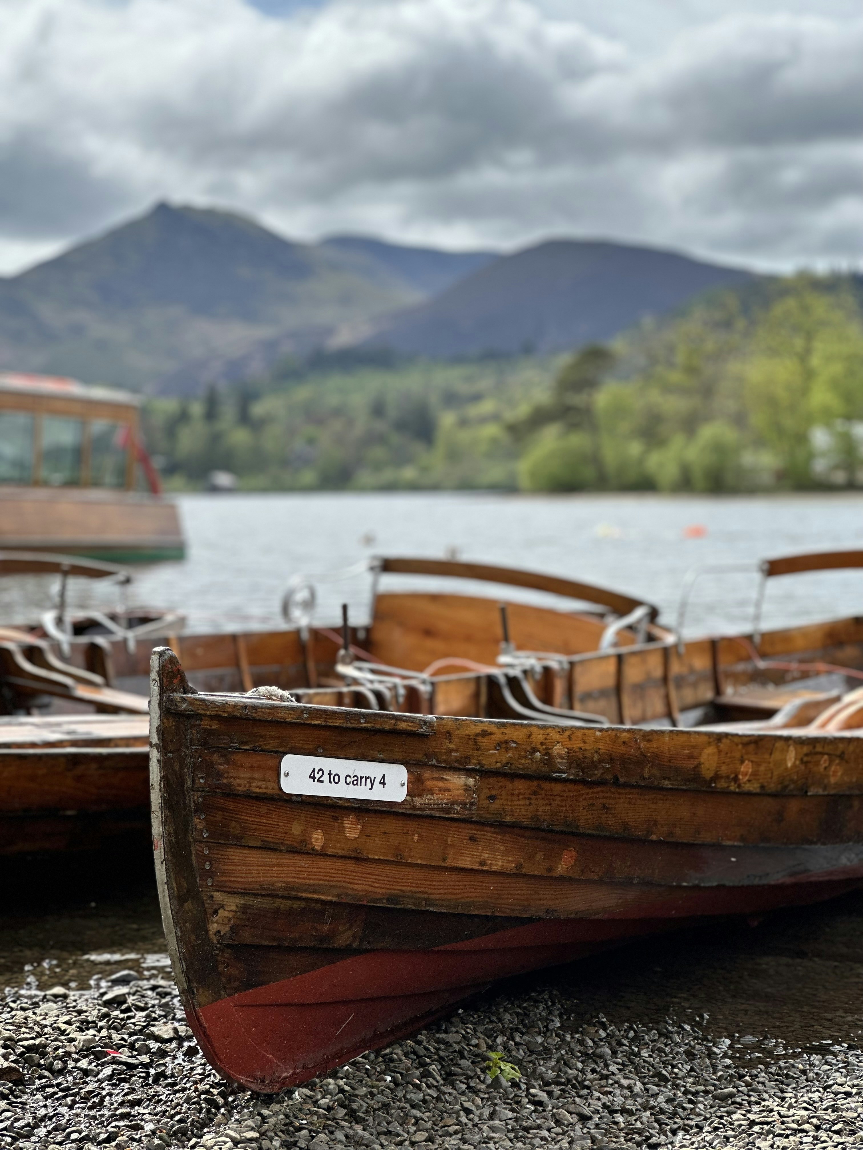 A row of wooden boats sitting on top of a lake photo – Free Outdoors ...