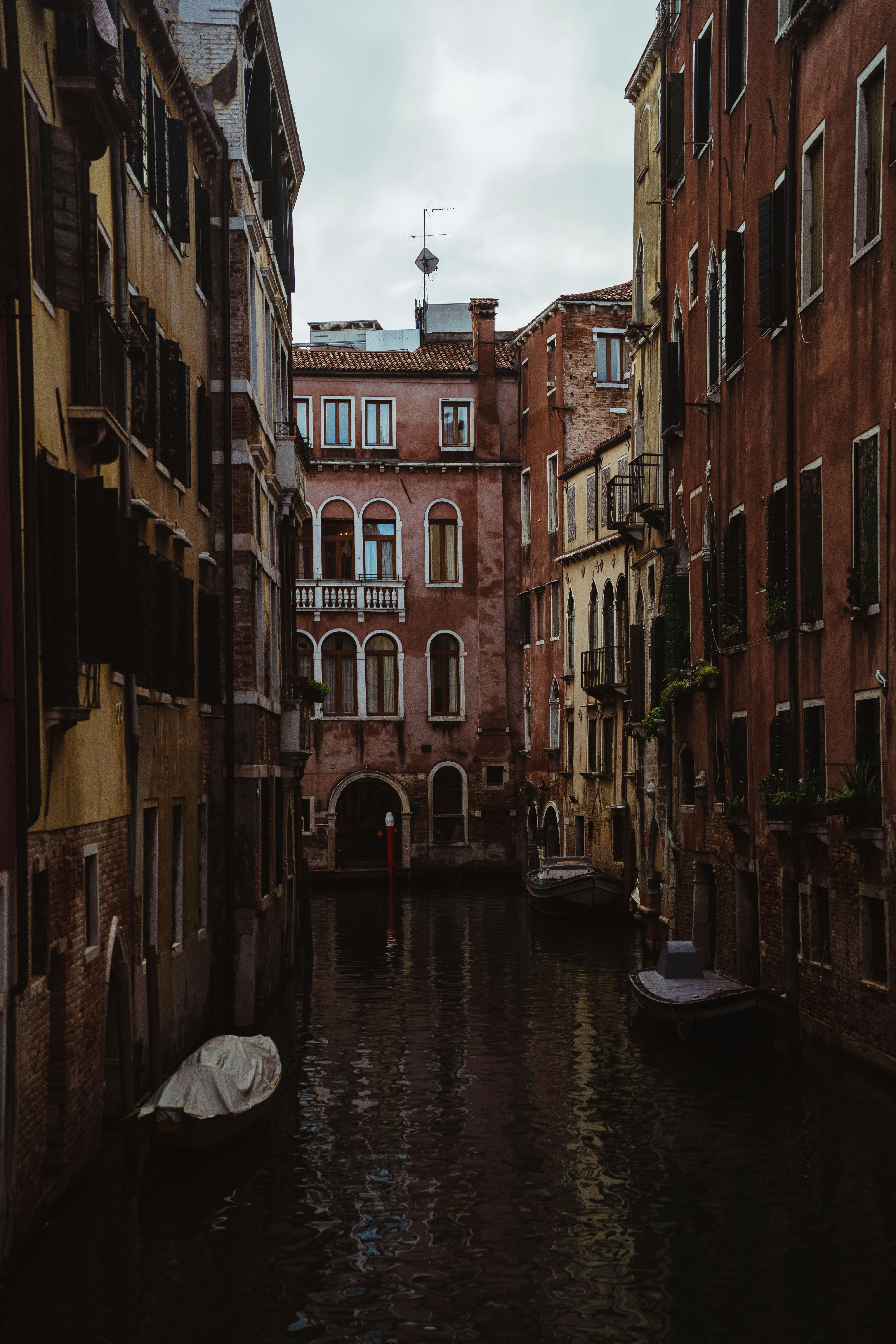 A boat floating down a river next to tall buildings photo – Free ...