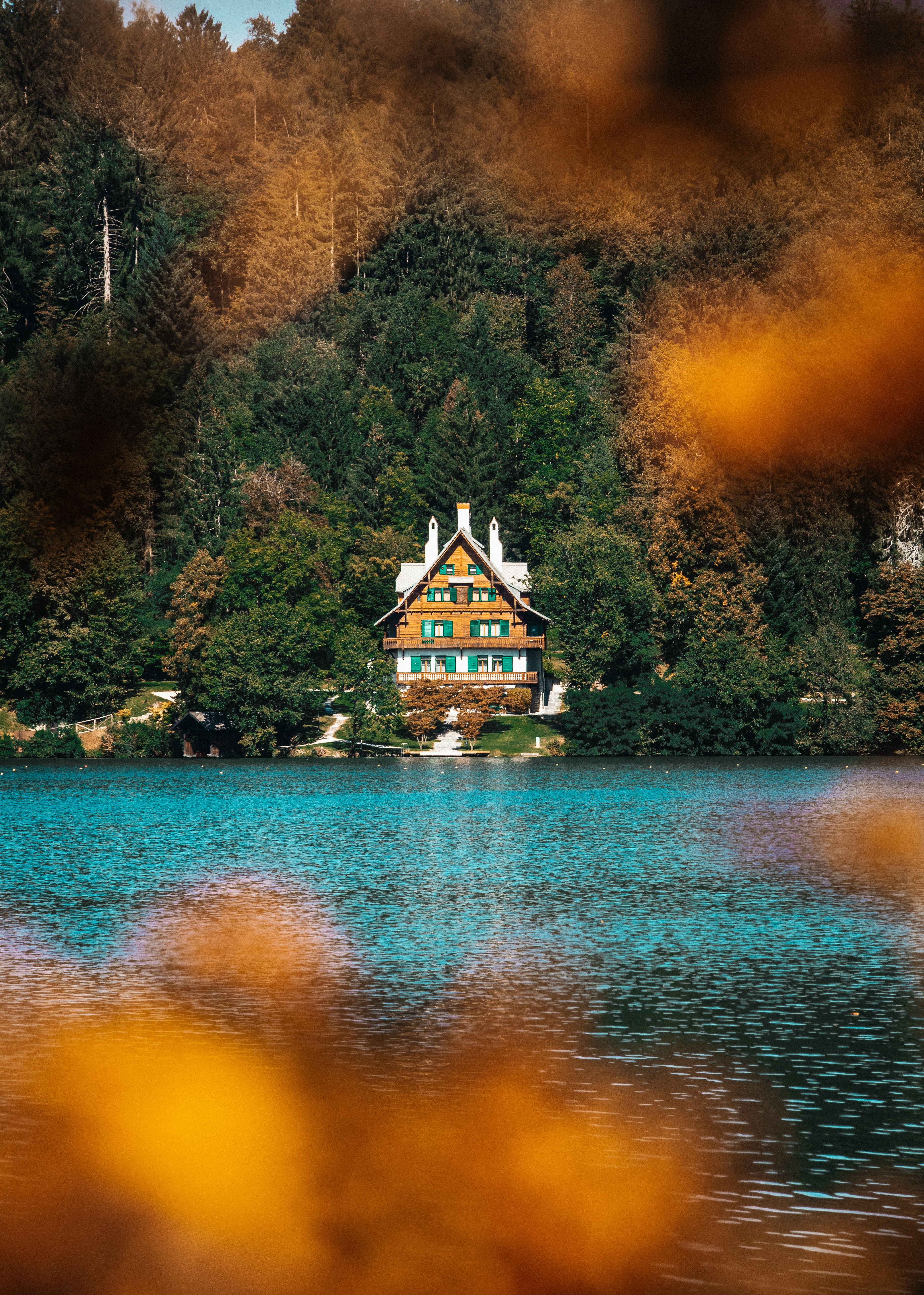 Chalet on a Turquoise Lake, Framed by Autumn Pines