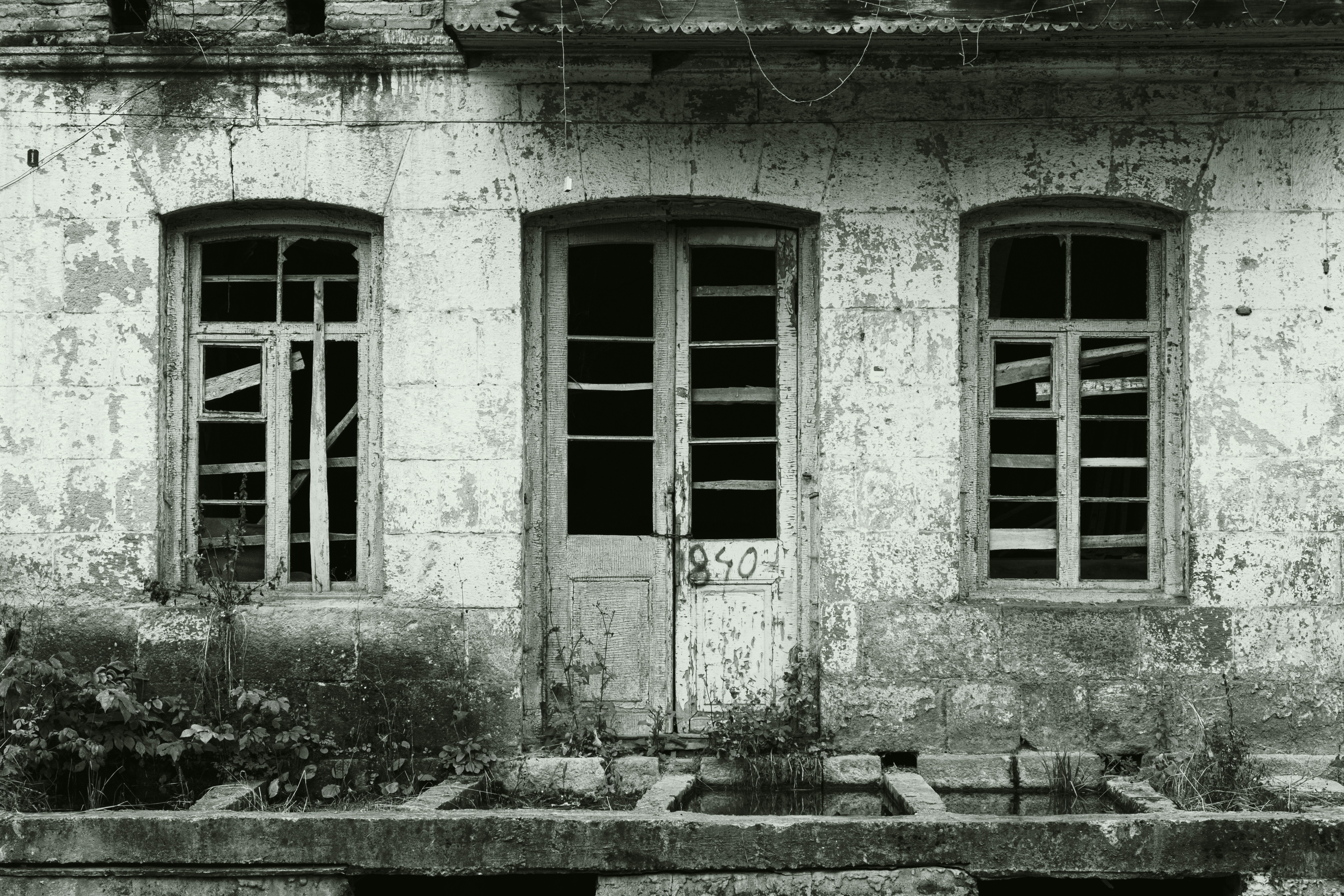Symmetry in Decay: Three Windows Framing a Worn Central Door