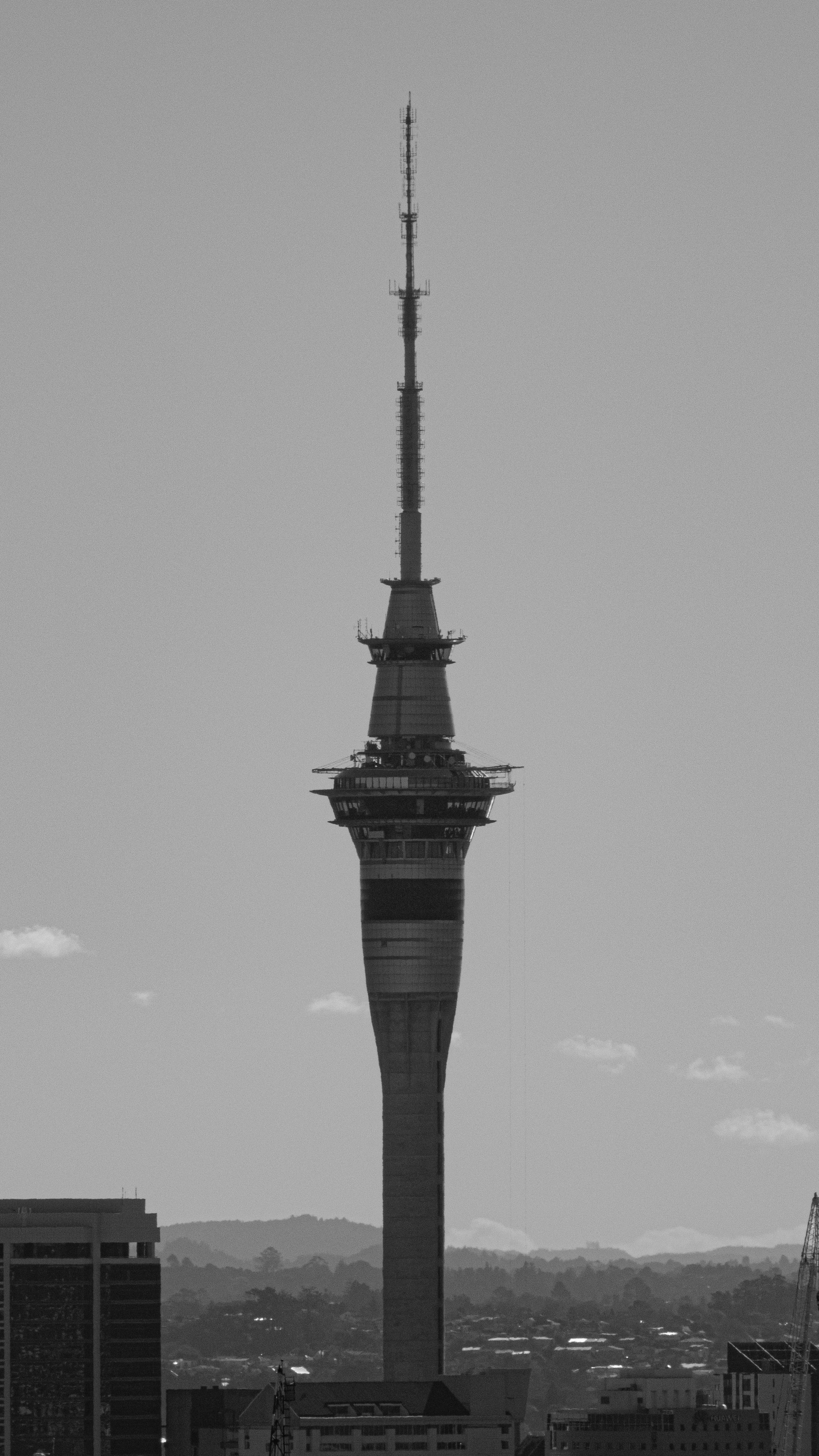 The Sky Tower in Auckland, New Zealand. | a black and white photo of a tall tower