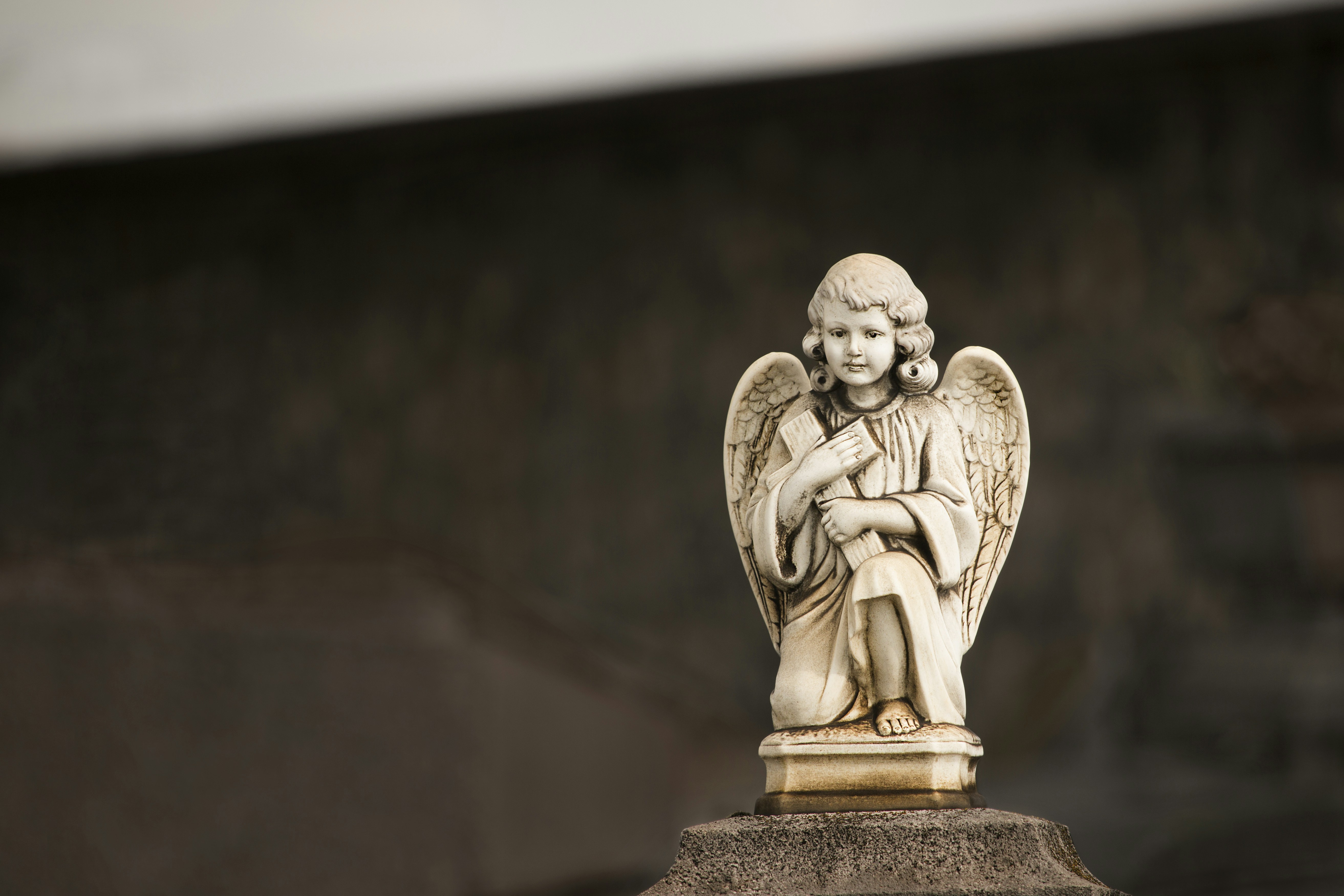 A statue of an angel sitting on top of a pillar photo – Free Paris ...