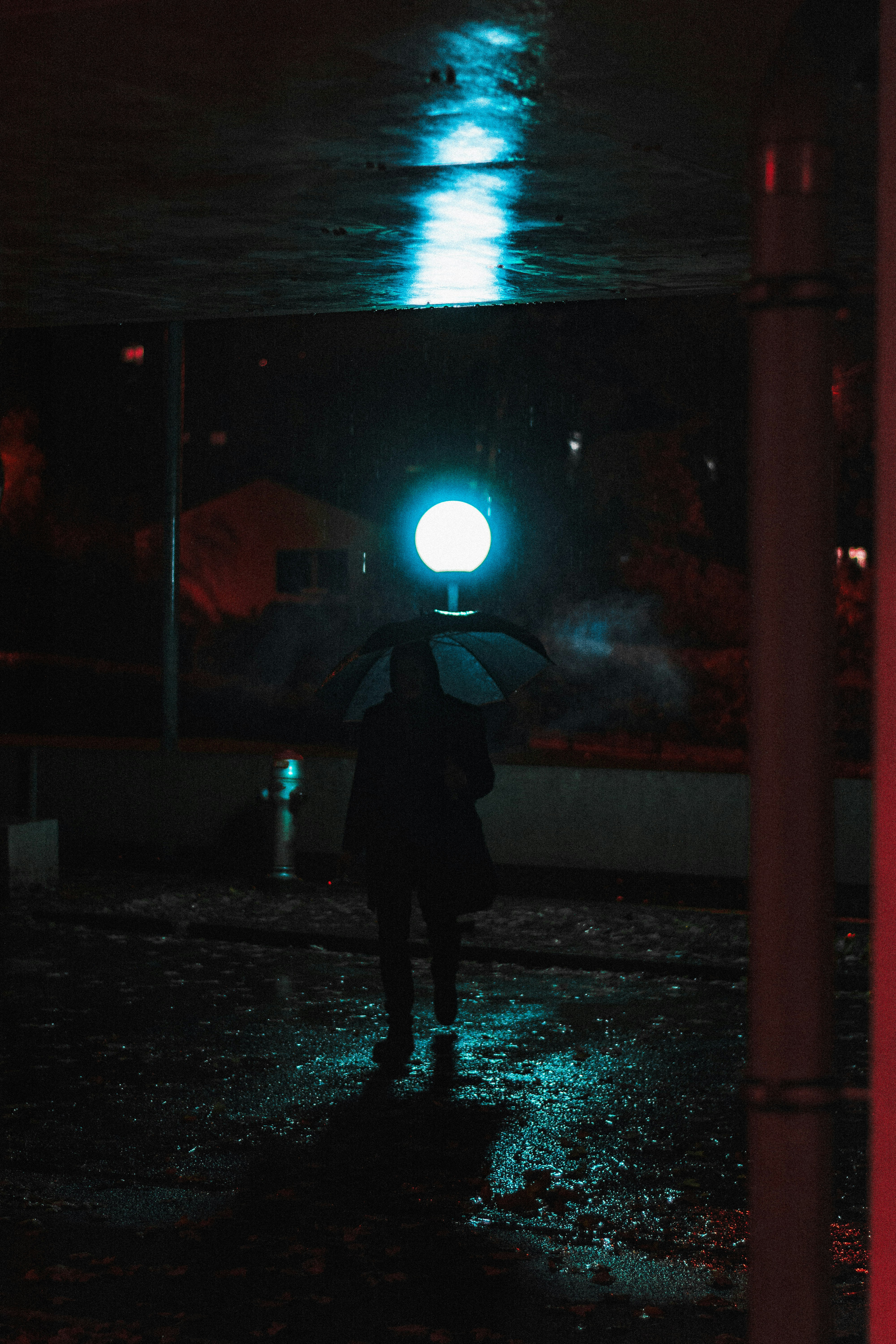 Umbrella Night: A Silhouette Beneath Neon Reflections