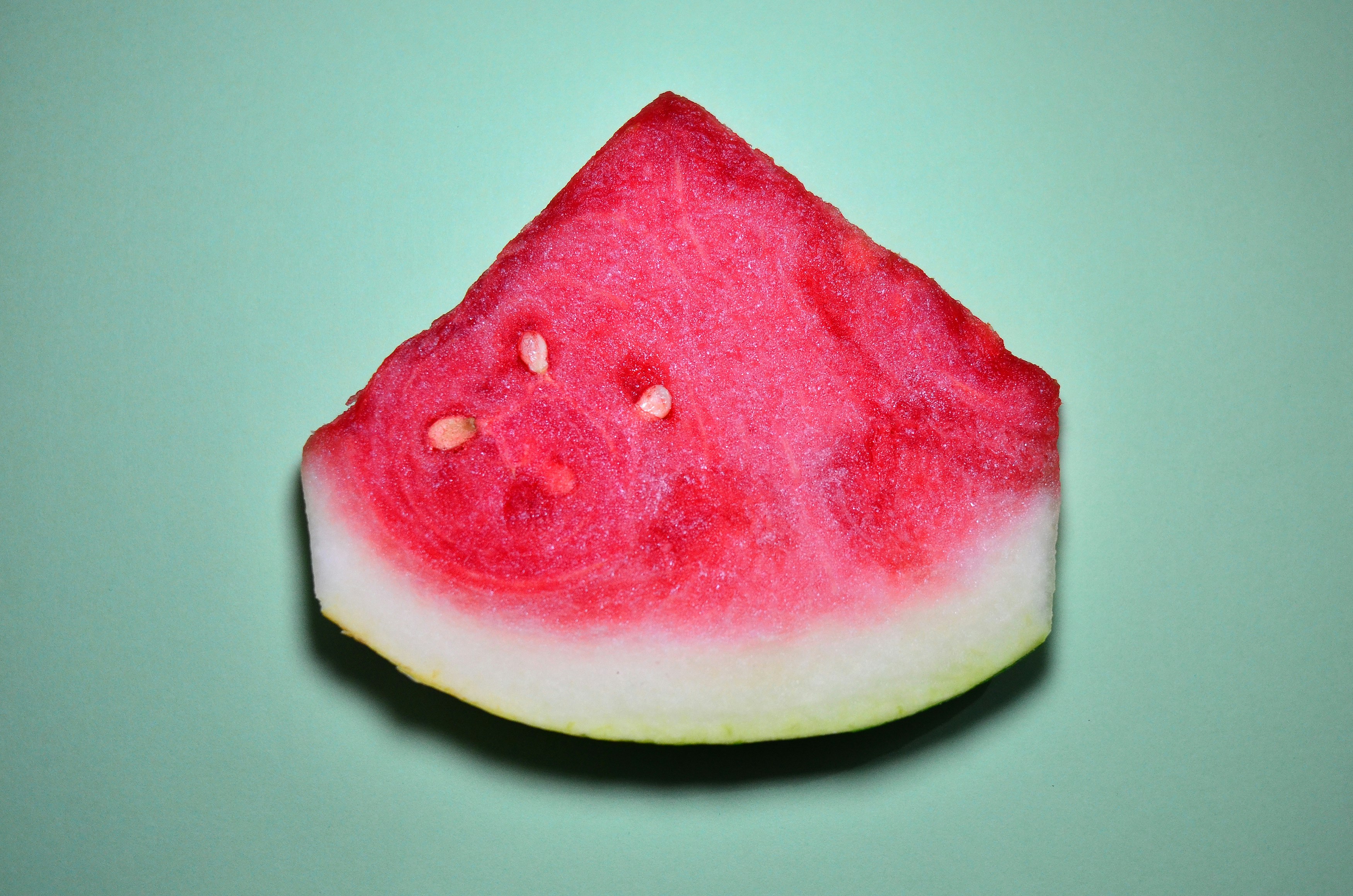 Teal Quiet: A Watermelon Wedge Resting on a Pale Mint Background